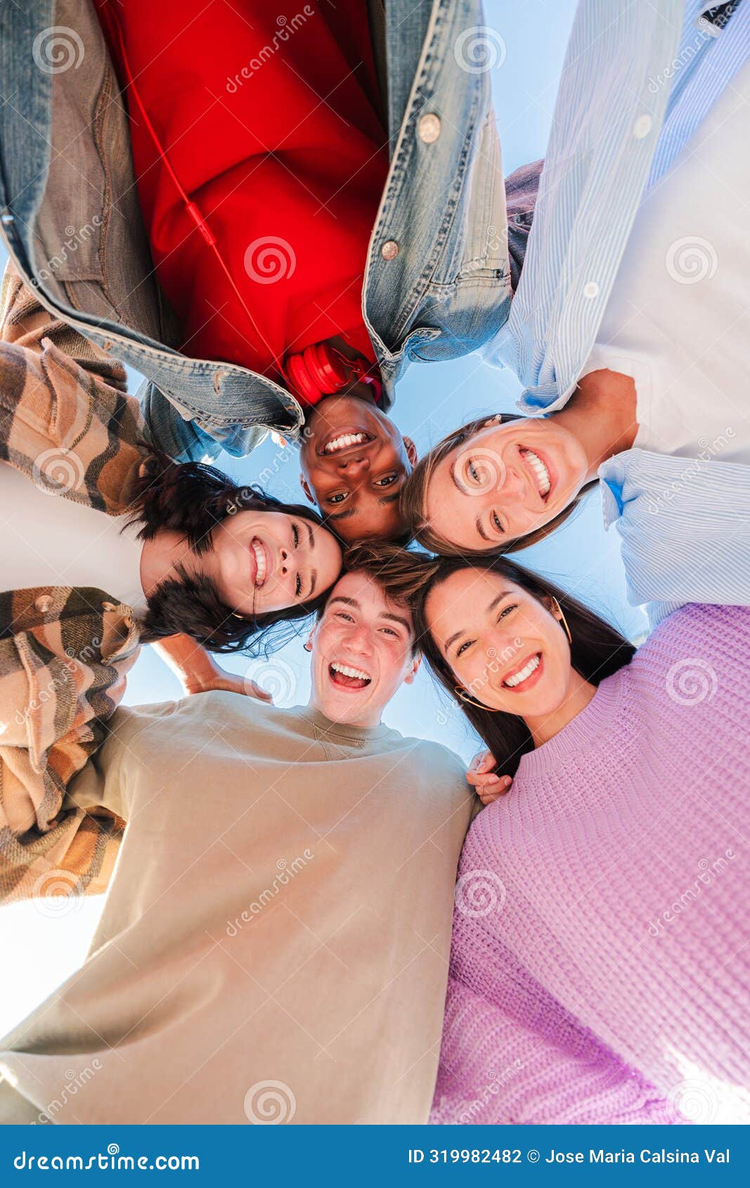 Vertical Low Angle View of a Group of Multiracial Young Friends Hugging ...