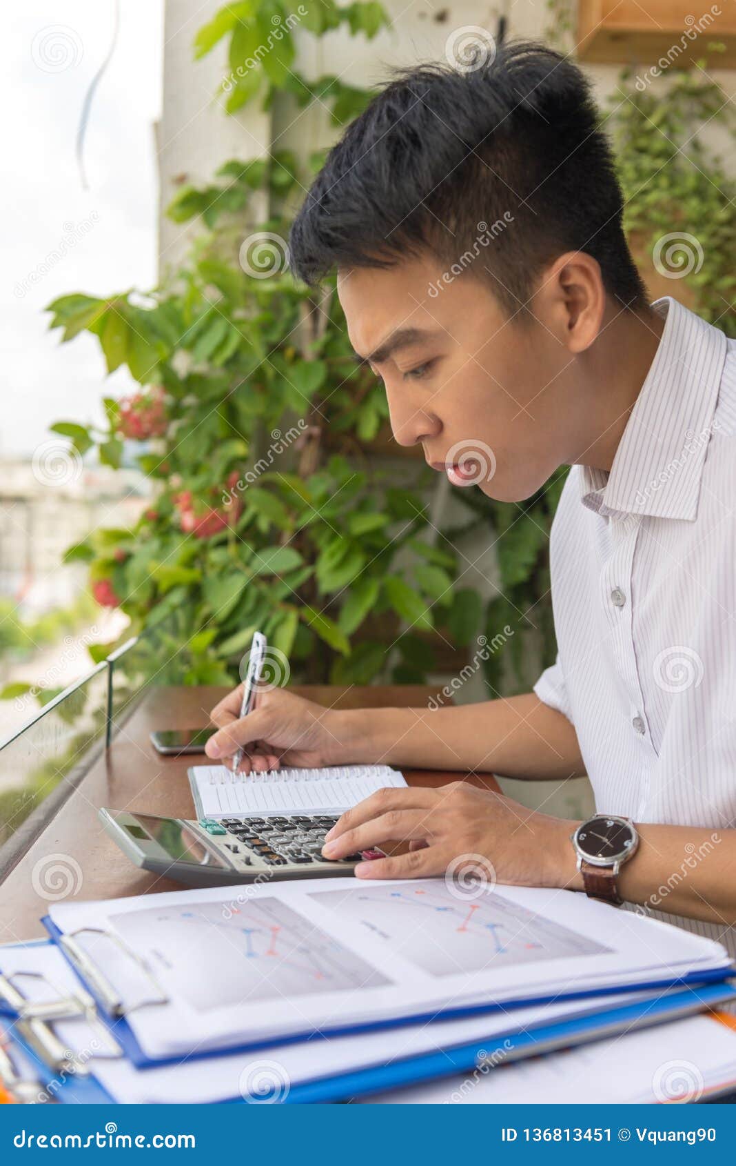 Young Man Doing Calculation on Calculator Stock Image - Image of ...
