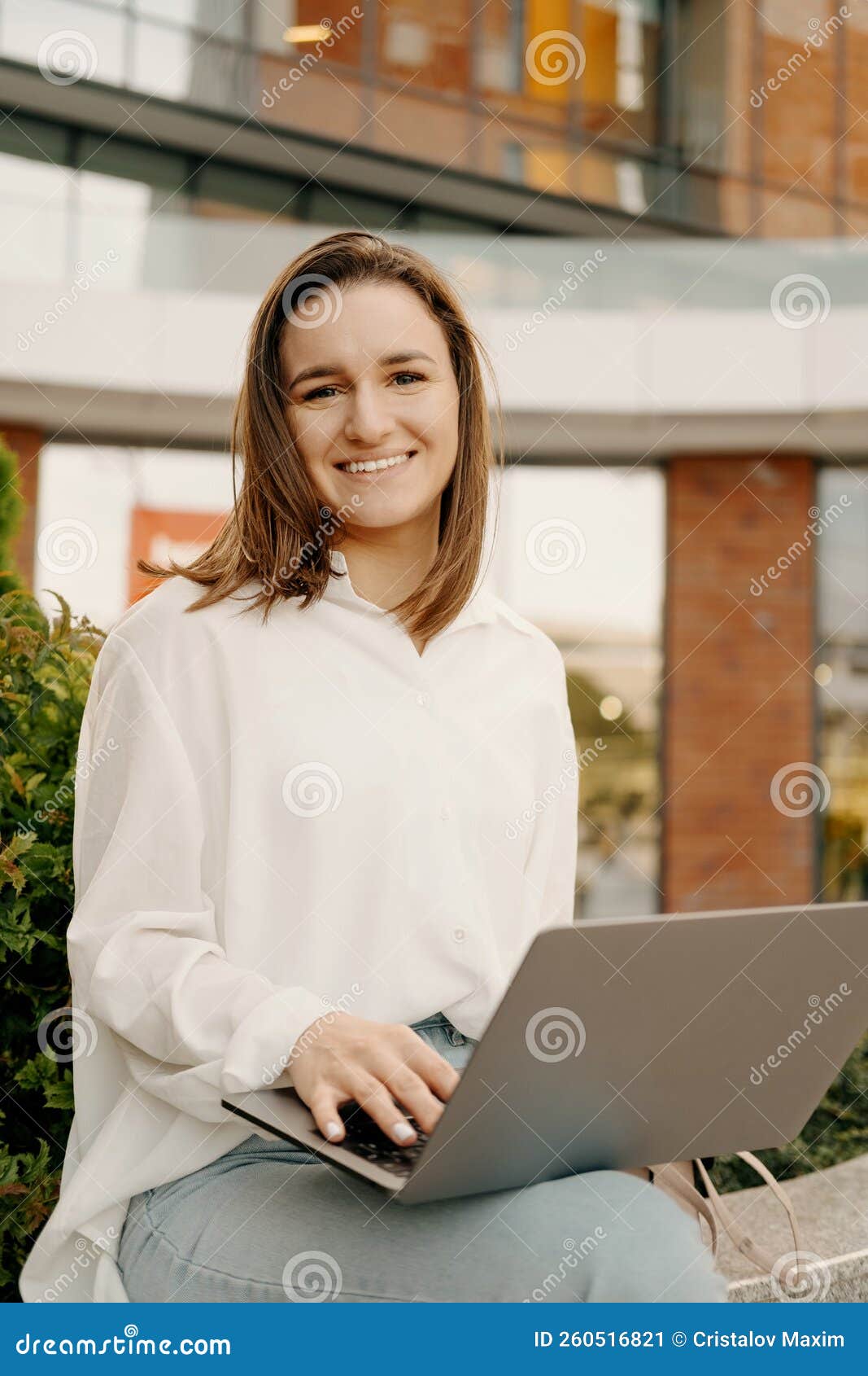 Vertical Photo of Young Smiling Woman Outdoor in City Working at Laptop ... Vertical Photo of Young Smiling Woman Outdoor in City Working at Laptop ...