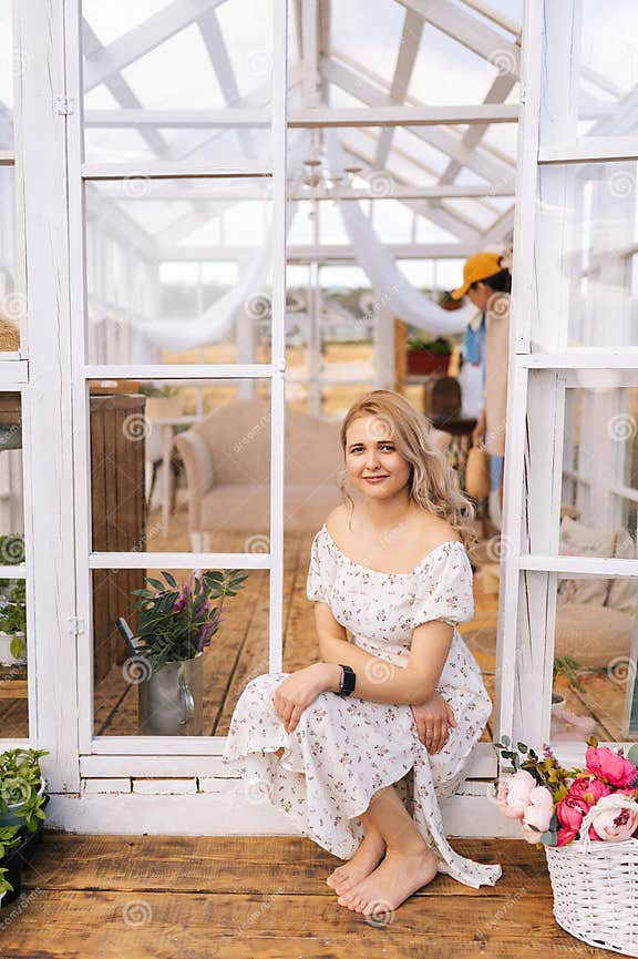 Vertical Portrait Of Happy Blonde Young Woman In Beautiful Dress Sitting In Doorstep Of Summer