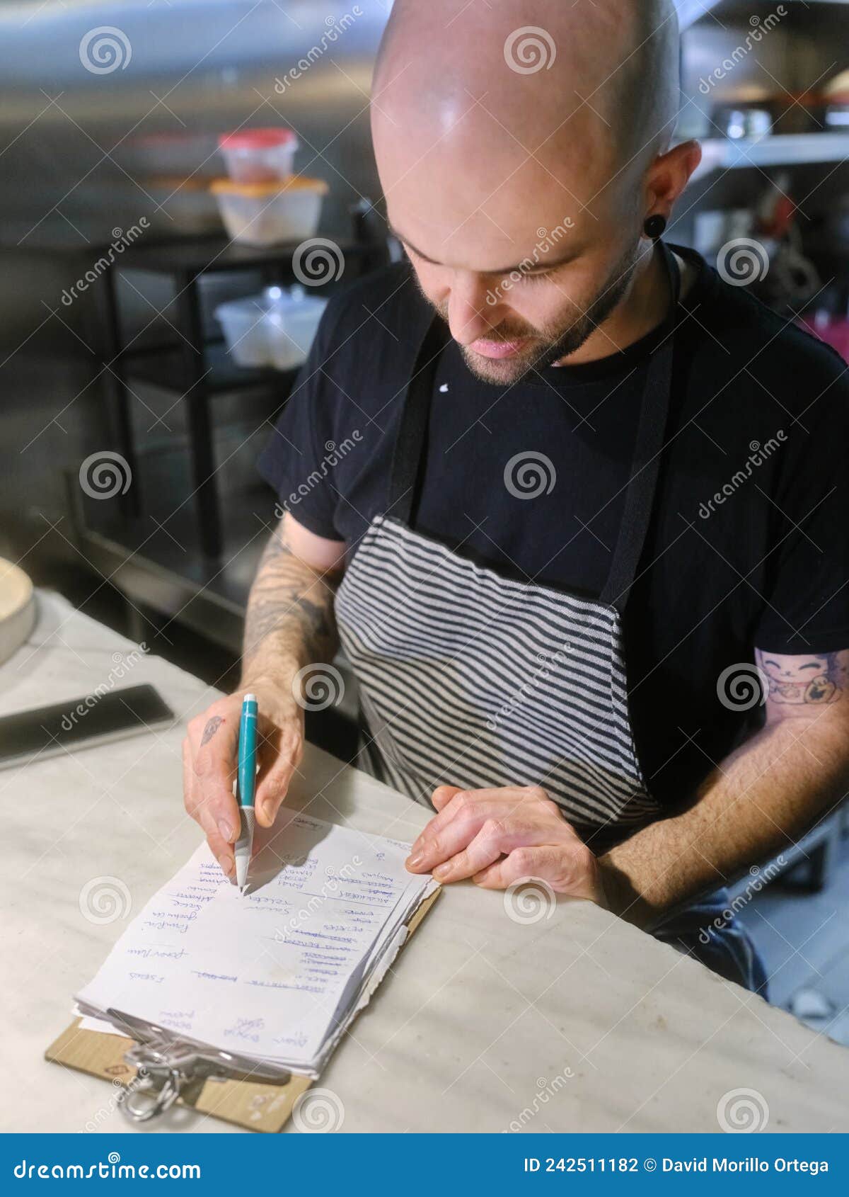 Cook Checking the List of Tasks To Prepare the Tasting Menu in a ...