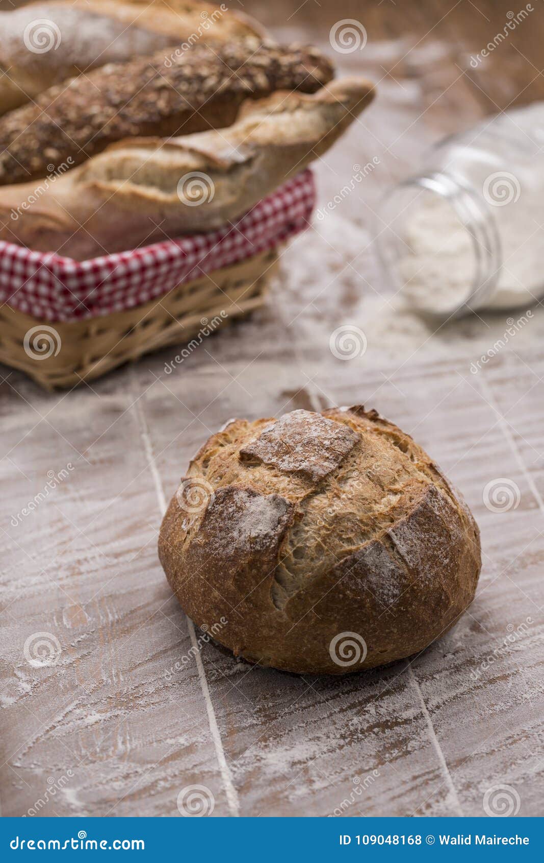 Round Bread with Basket of Various Bread Forms on Wooden Table Stock ...