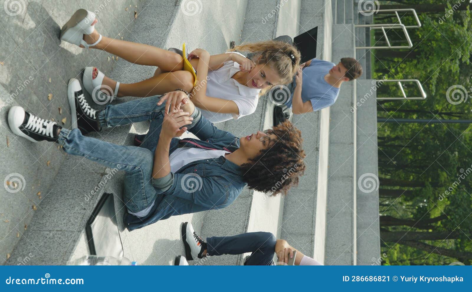 Vertical Screen: Multiethnic Students Relaxing on Stairs after Classes ...