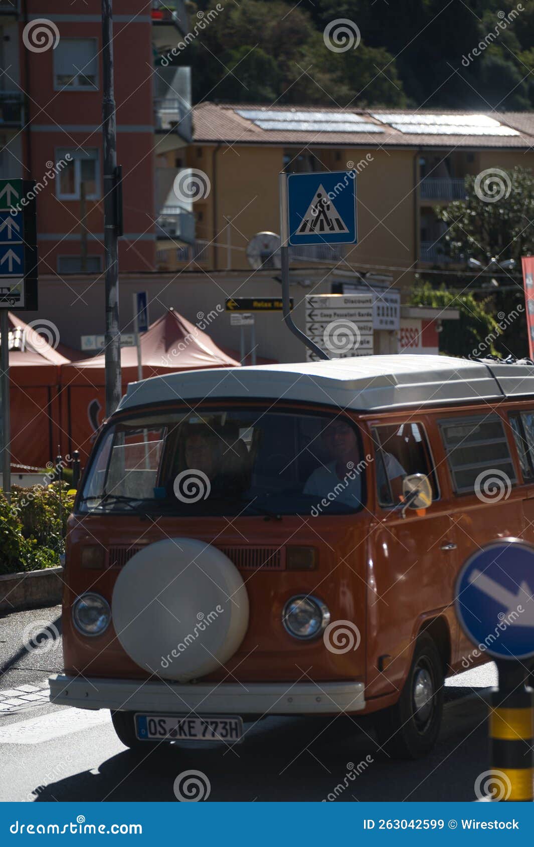 Vertical Selective Focus of an Orange Van with Traffic Signs and ...