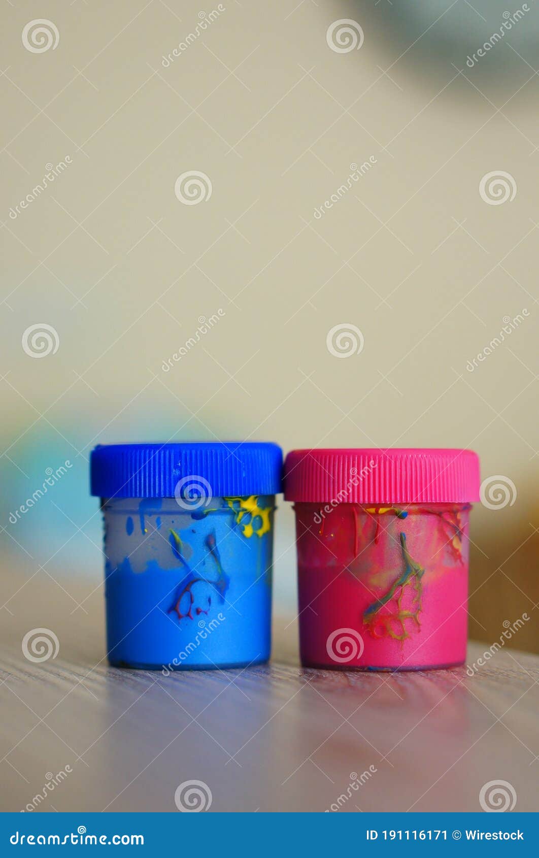 Vertical Selective Focus Shot of Small Red and Blue Paint Containers on ...