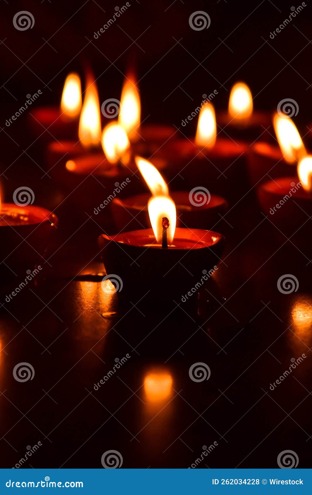 Vertical Shallow Focus Shot of Small Candles Burning in a Dark Room on ...