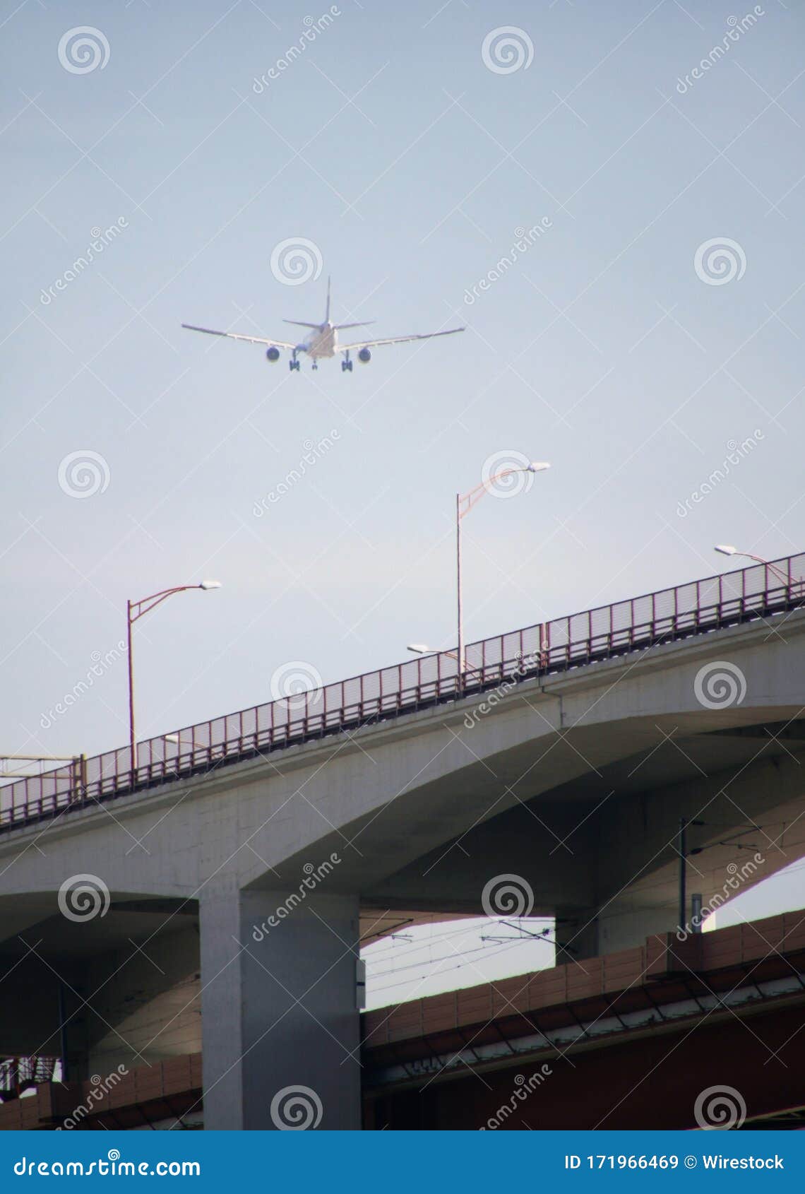 Vertical Shot of an Airplane Flying Over a Bridge Stock Image - Image ...