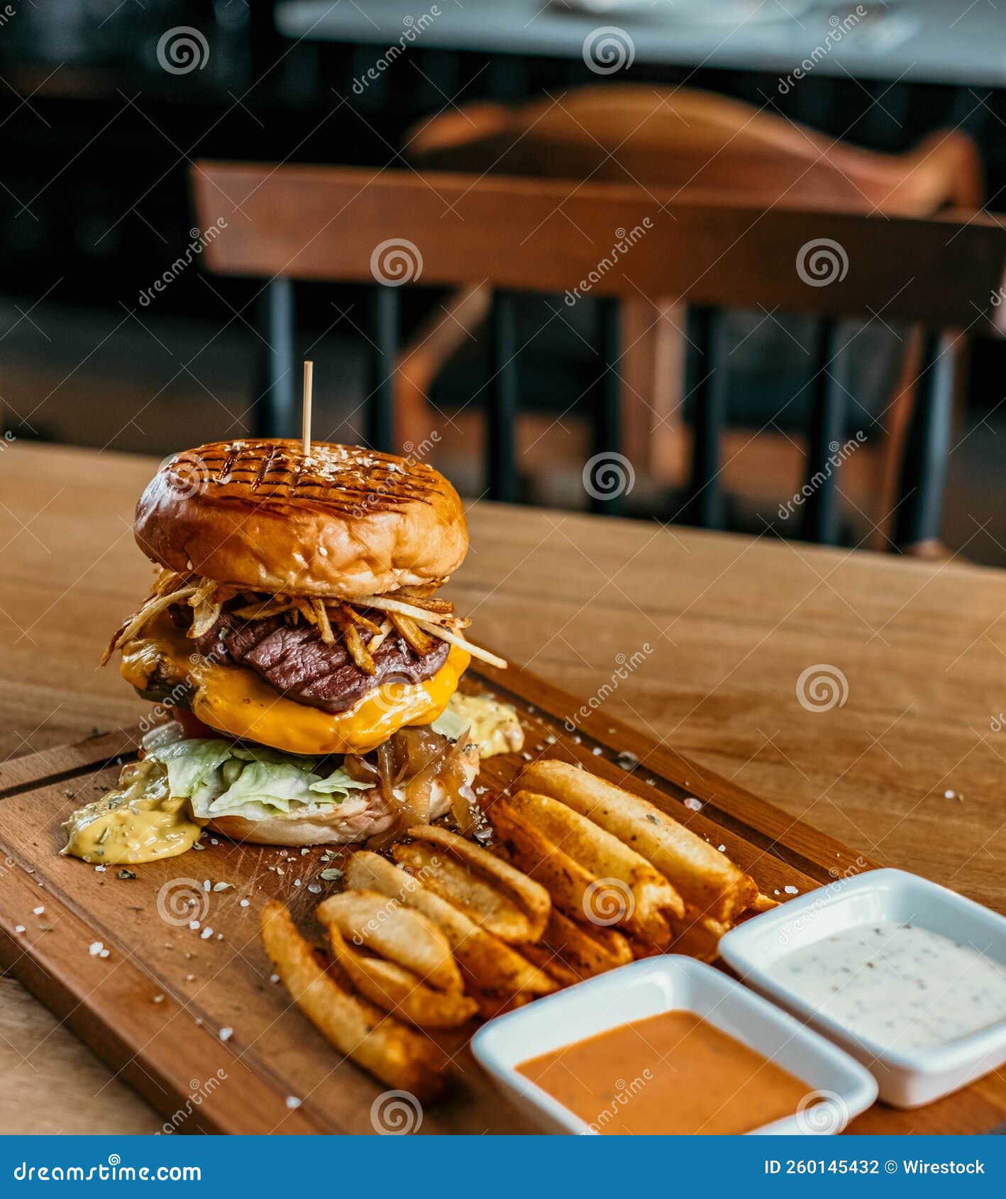 Vertical Shot of an Appetizing Double-sized Burger Served with Fries ...
