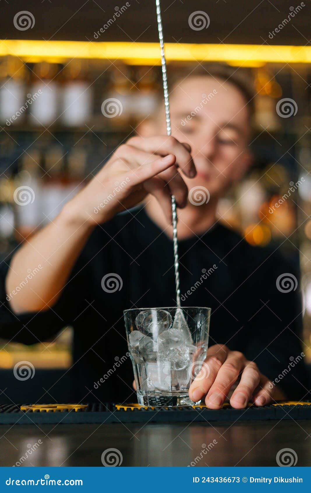 Vertical Shot of Bartender Stirring Ice Cubes in Glass Using Long Bar ...