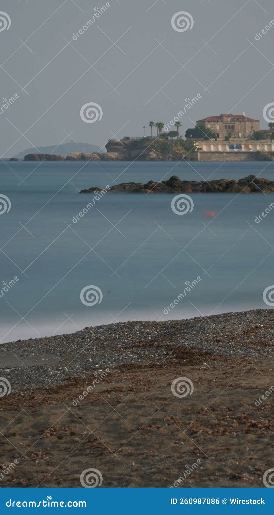 Vertical Shot from the Beach of the Sea and Building with Palms on the ... Vertical Shot from the Beach of the Sea and Building with Palms on the ...