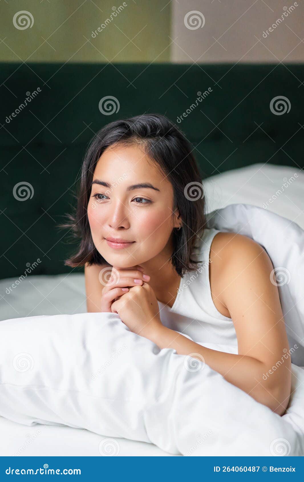 Vertical Shot Of Beautiful Asian Woman Lying In Her Bed On Pillow