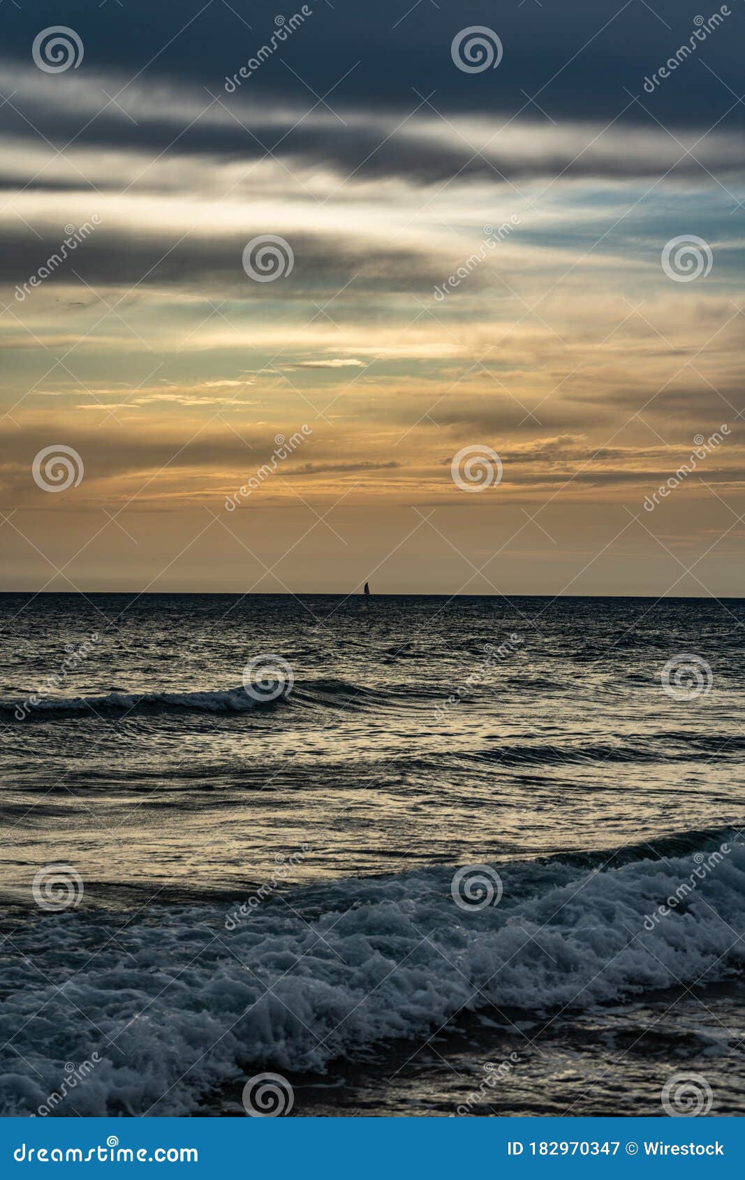 Vertical Shot of the Beautiful Ocean Waves Captured Under the Sunset in ...