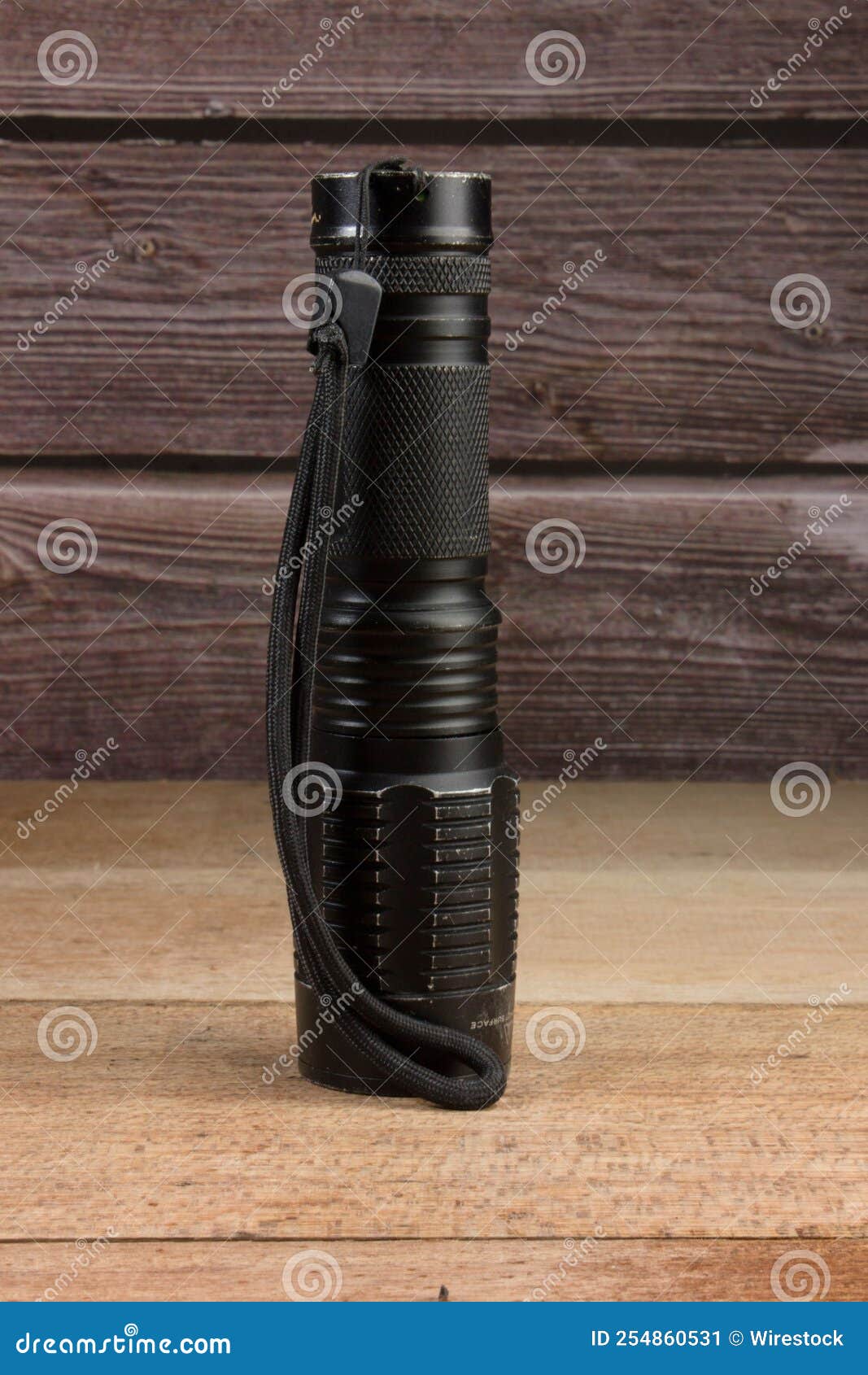 Vertical Shot of a Black Technical Torch Light on a Wooden Surface ...