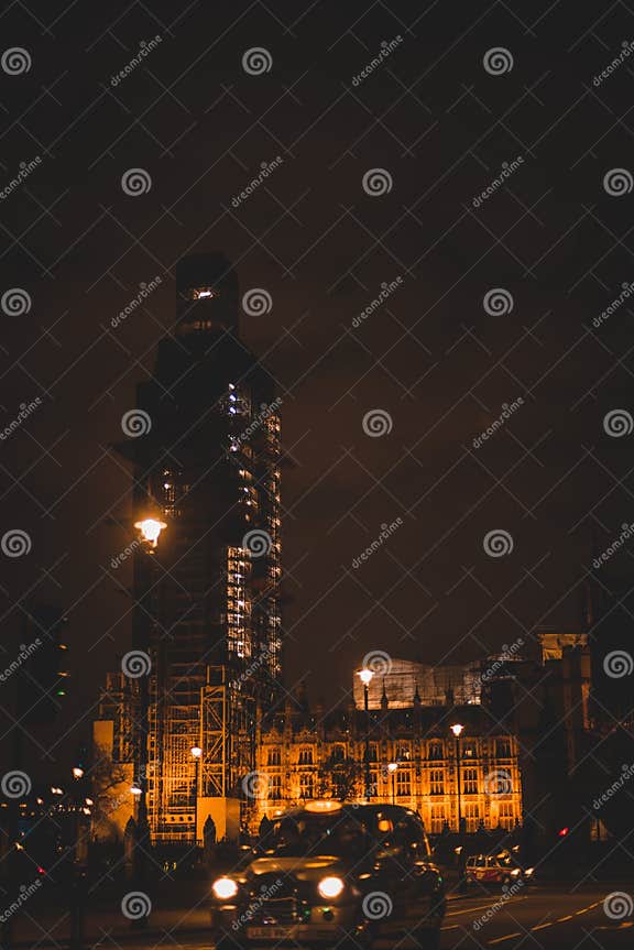 Vertical Shot of a Building Under a Clouded Sky at Night Stock Photo ...