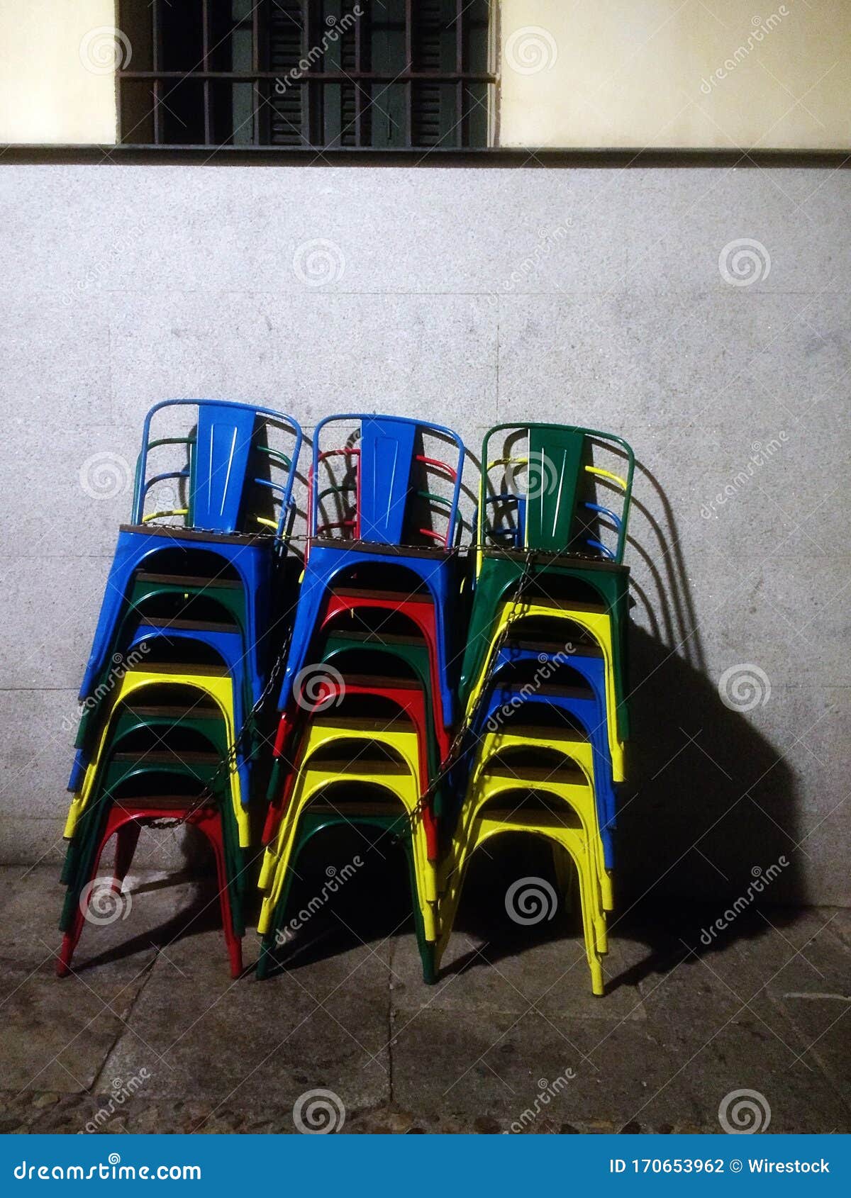 Vertical Shot of Chairs of Multiple Colors Stacked on Top of Each Other ...