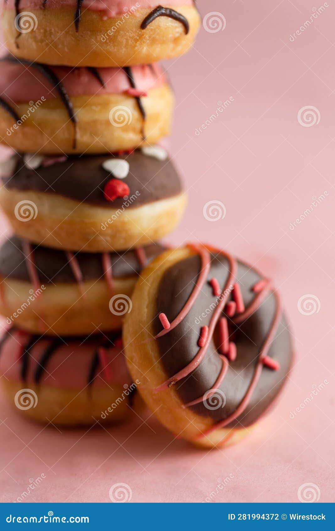 Vertical Shot of a Chocolate Donut with Red Stripes Leaning on a Stack ...