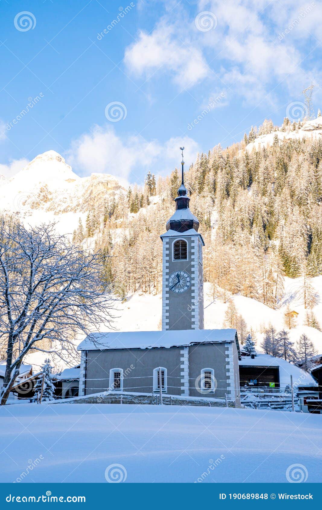 Vertical Shot of a Clock Tower with Snow-covered Mountains in the ...