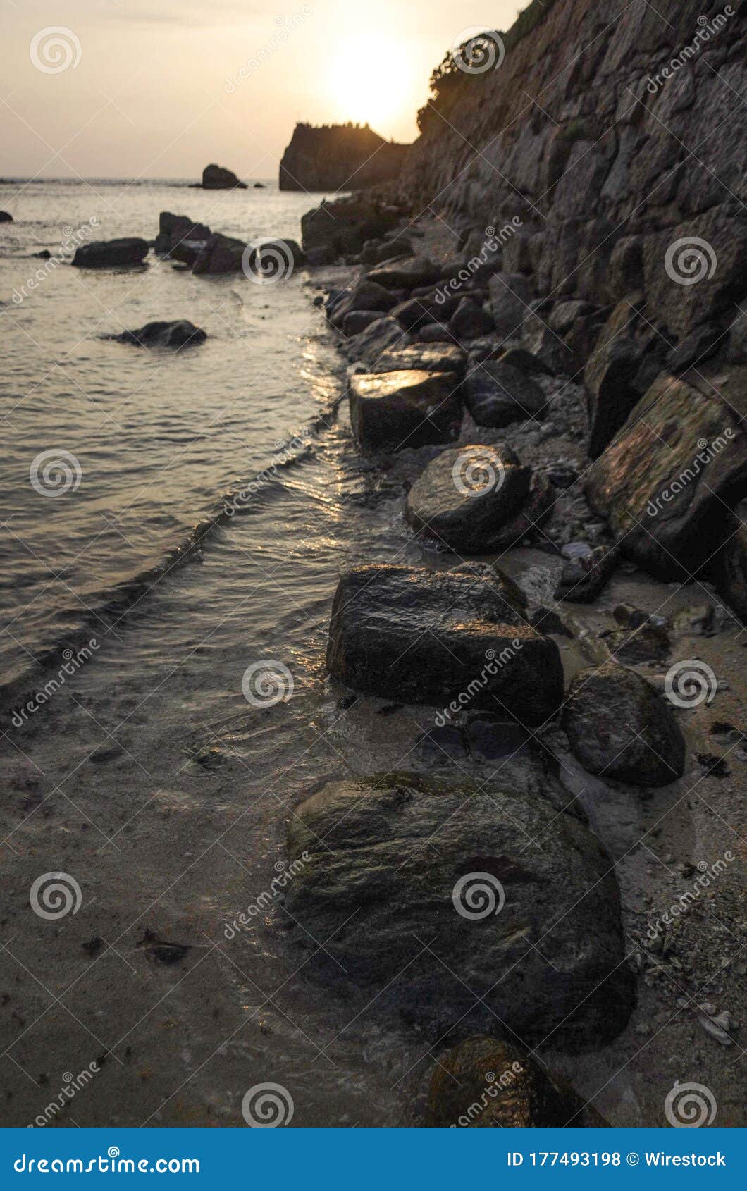Vertical Shot of a Coastal Rock Barrier at Sunset Stock Photo - Image ...