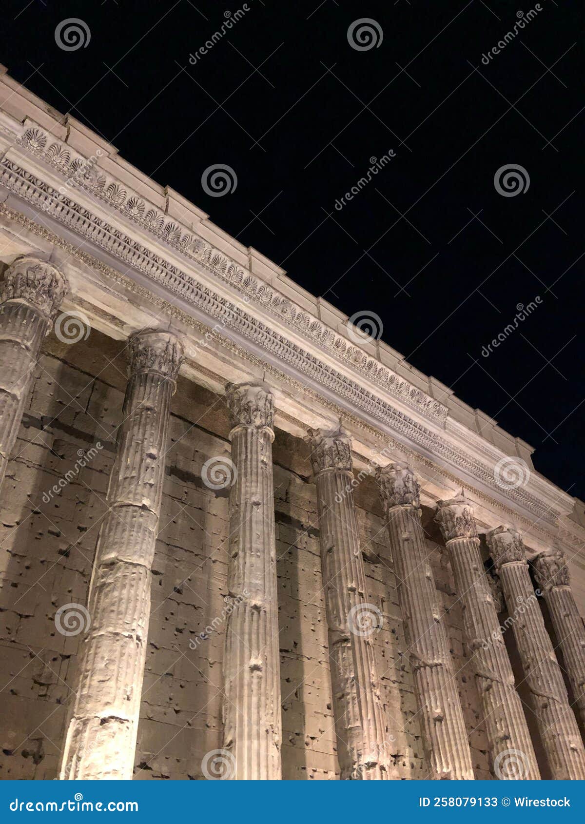Vertical Shot of the Columns of the Temple of Hadrian in Rome at Night ...