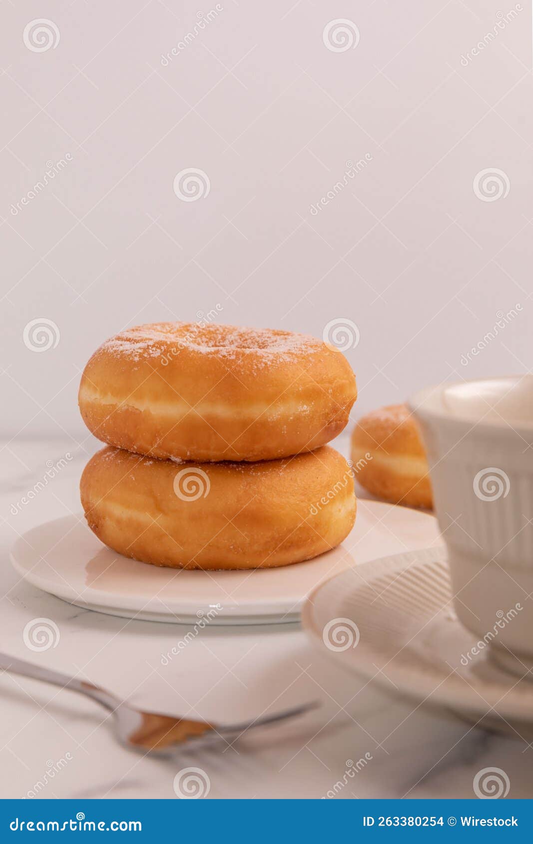 Vertical Shot of Donuts Served with Coffee on a White Table Stock Photo ...