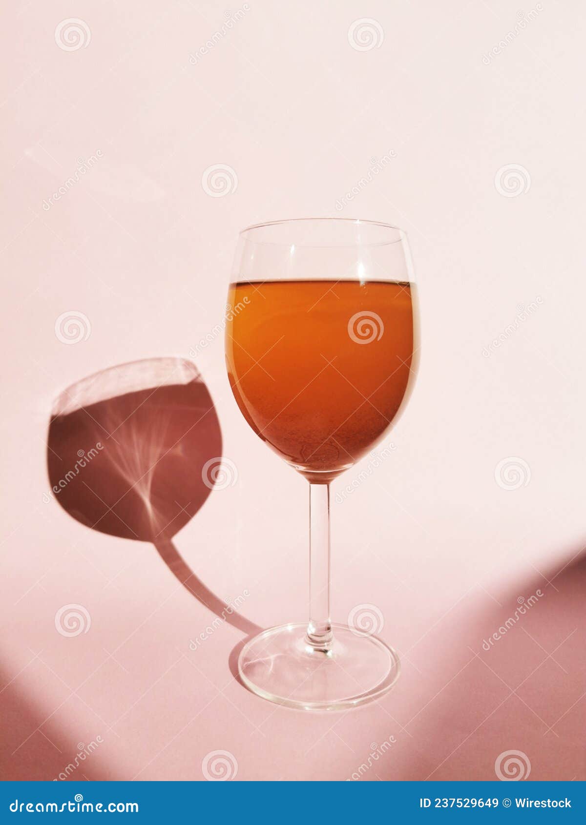 Vertical Shot of a Drink in a Wine Glass on a Pink Background Stock ...