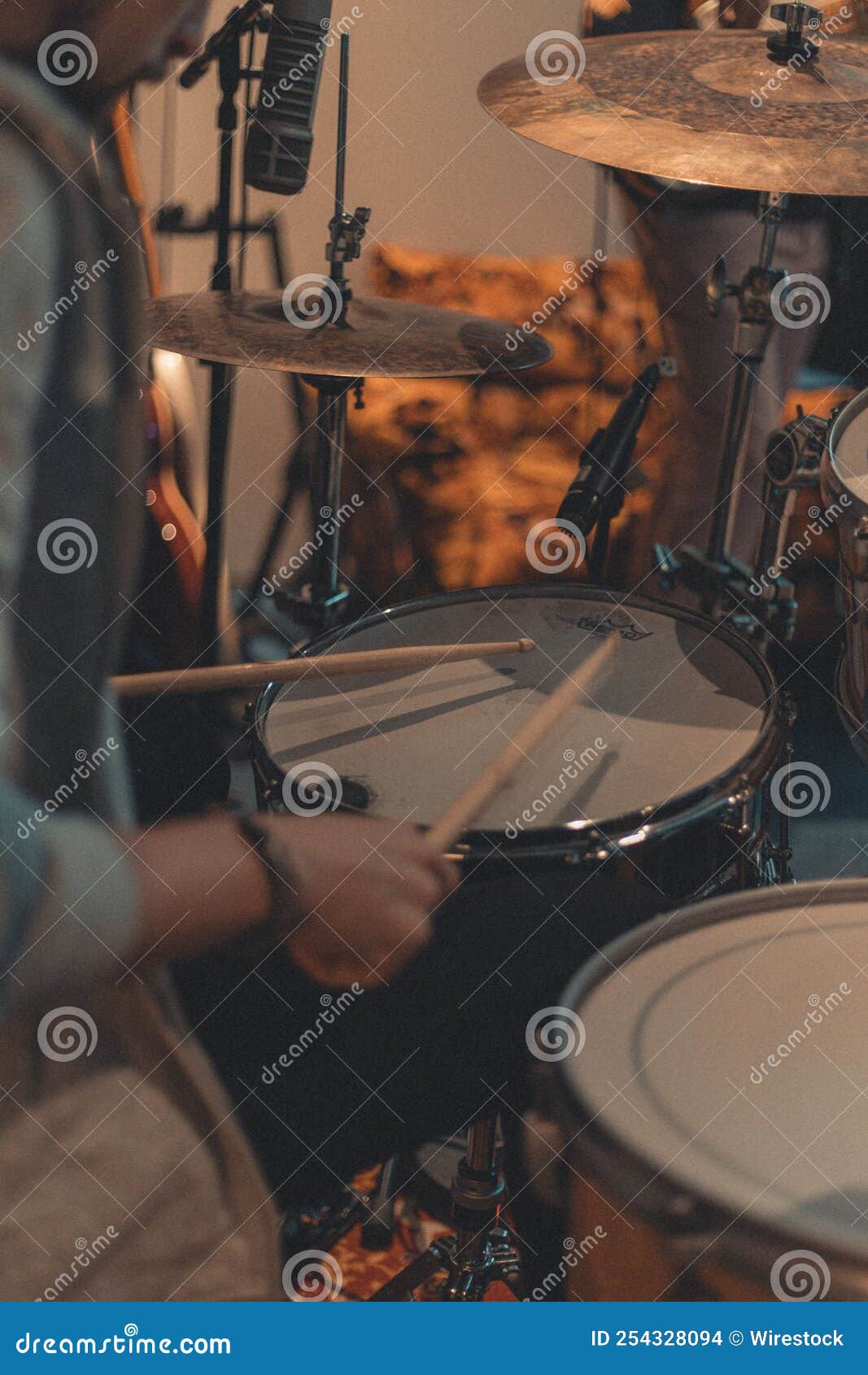 Vertical Shot of Drum Kit with a Male Playing Them Stock Photo - Image ...