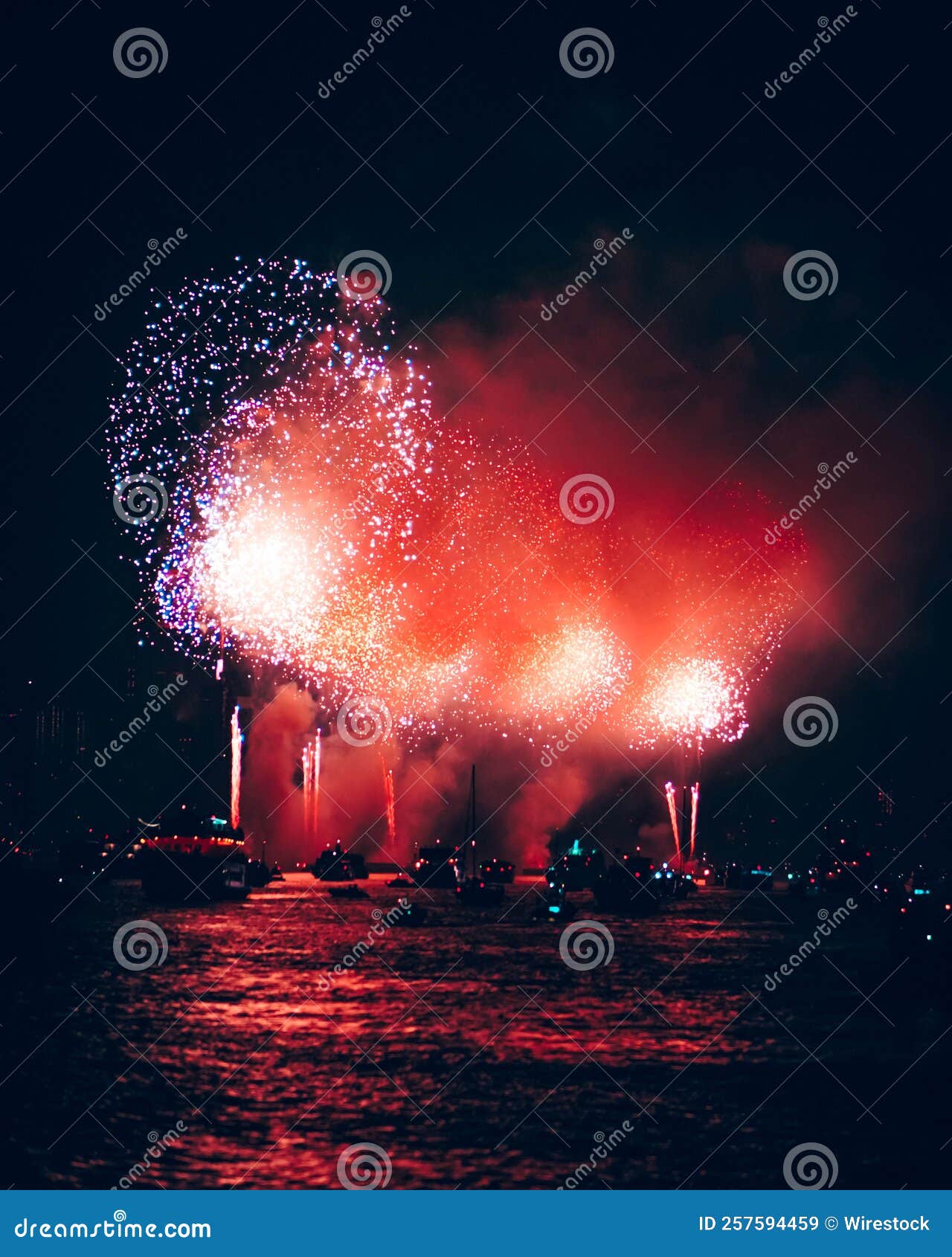 Vertical Shot of Exploding Bright Red July 4th Fireworks Over Water ...