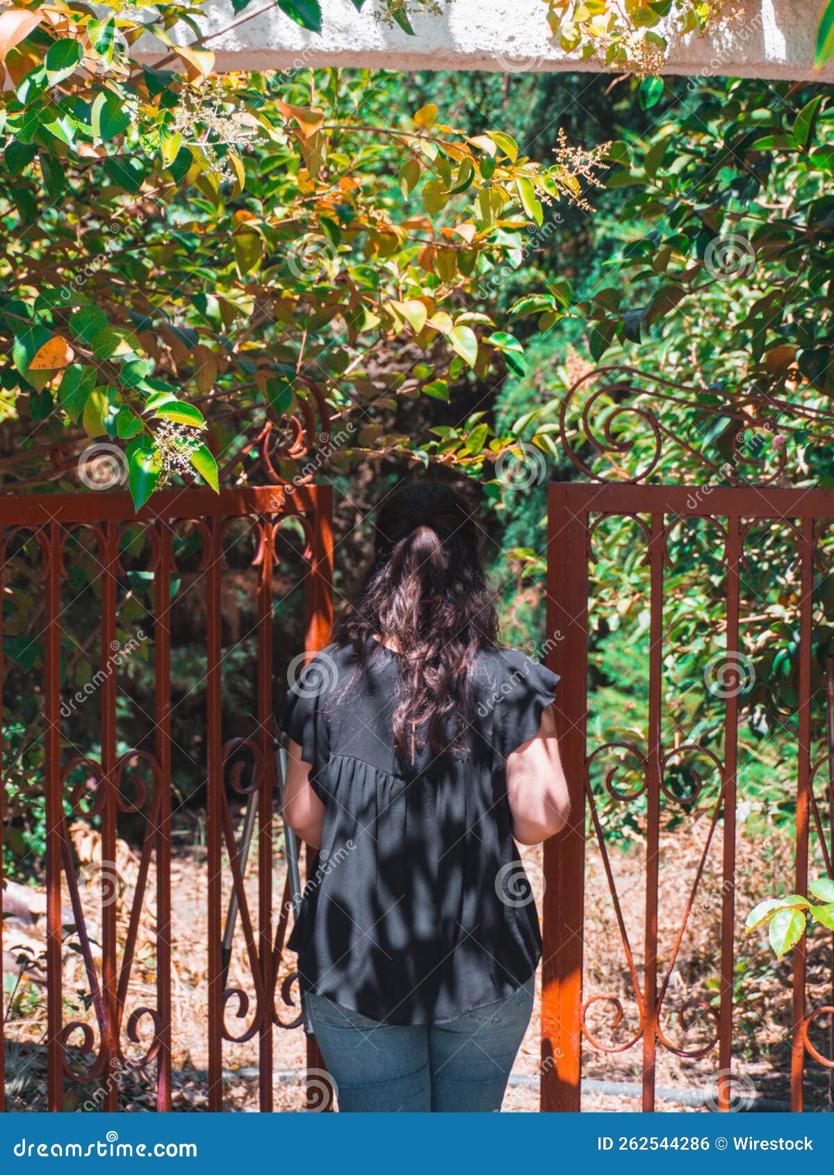 Vertical Shot of a Female Entering the Garden through a Gate Stock ...
