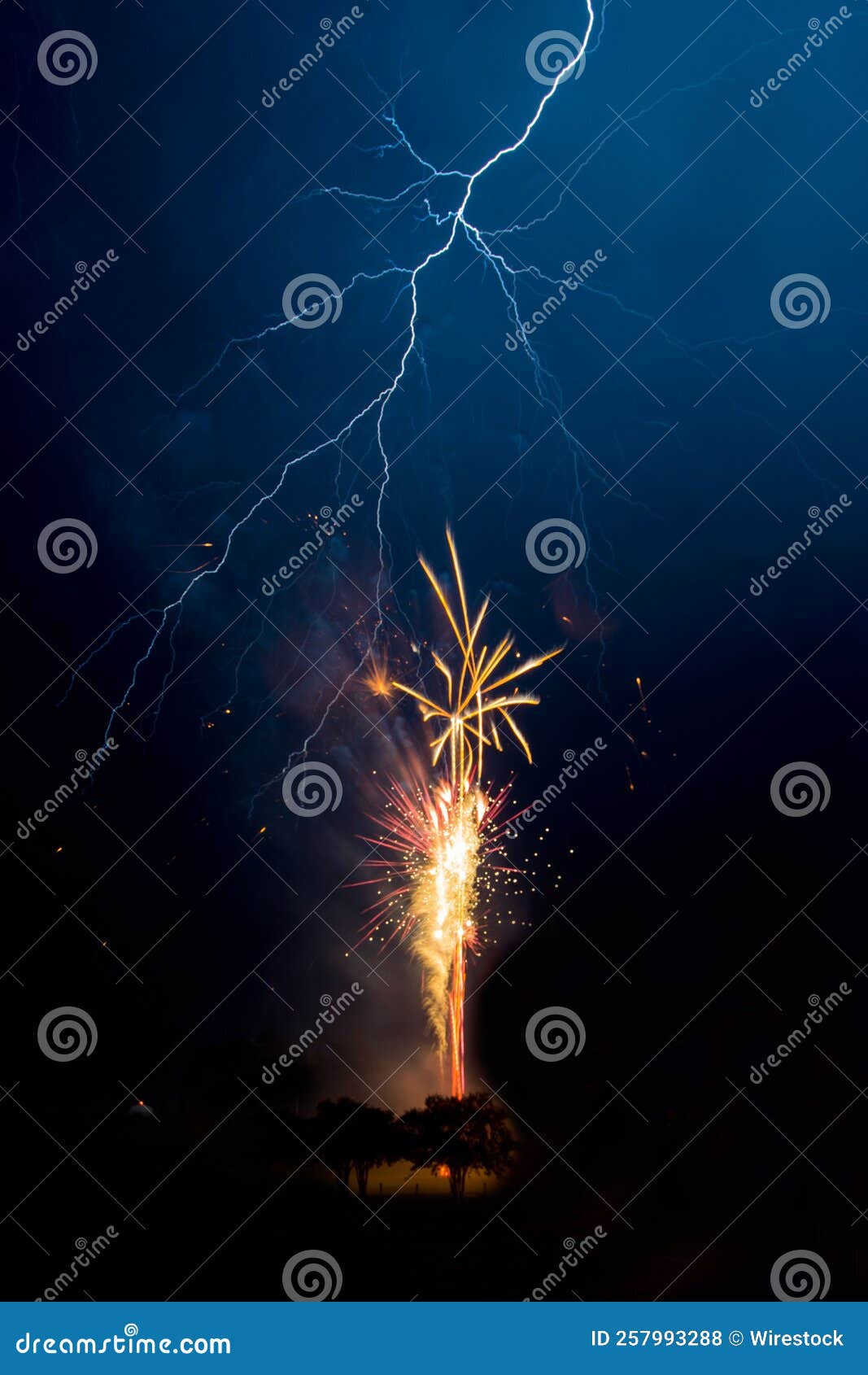 Vertical Shot of Fireworks Exploding in a Night Sky while Lightning ...