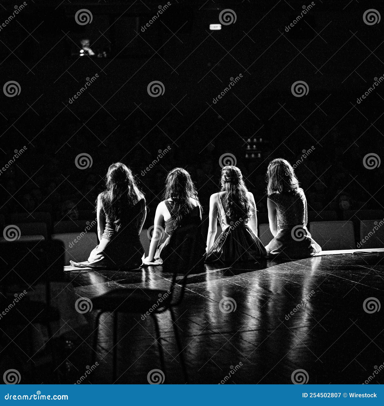 Vertical Shot of Four Girls Sitting on the Stage. Stock Image - Image ...