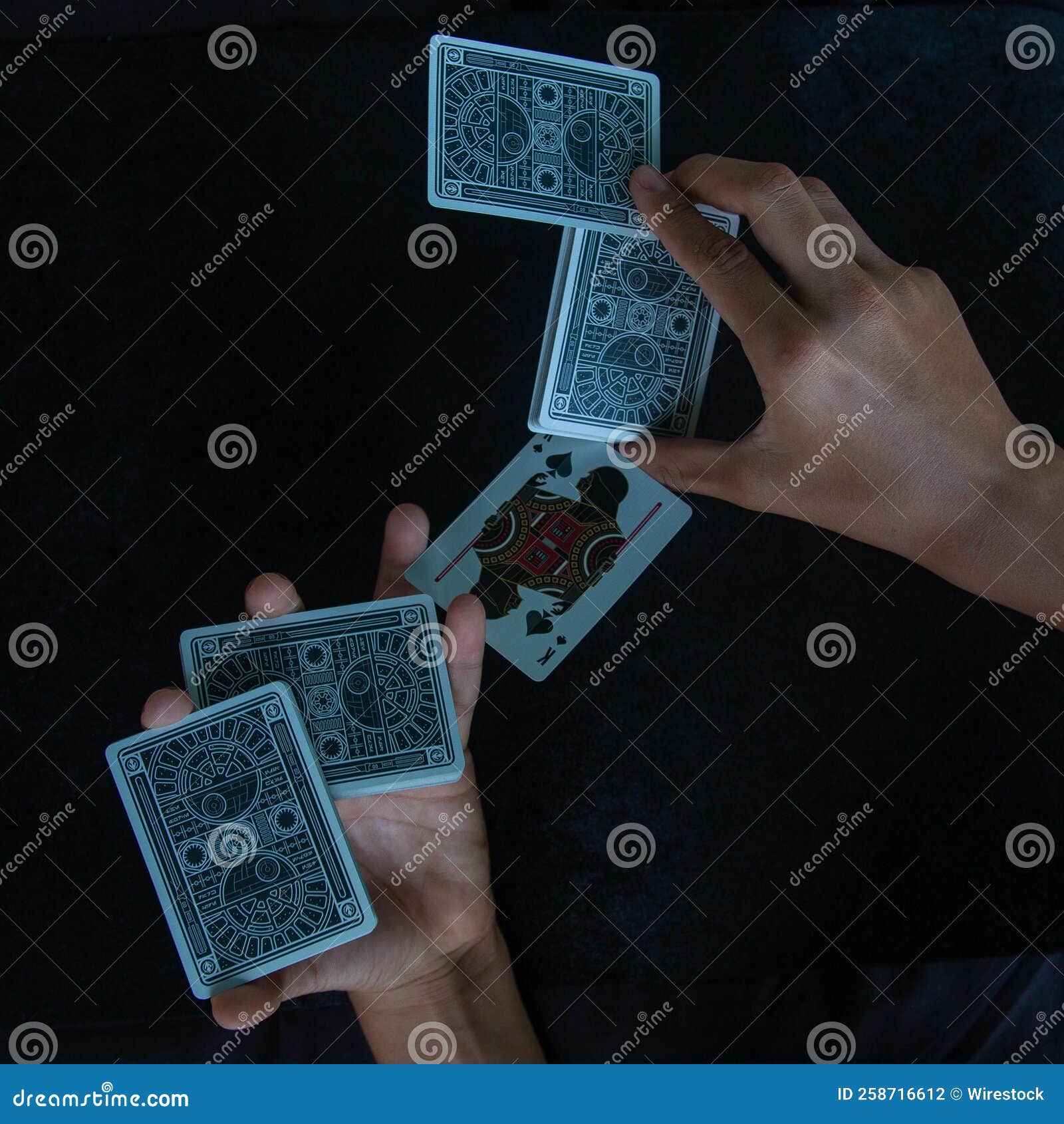 Vertical Shot of Hands Playing with a Deck of Poker Cards on a Dark ...