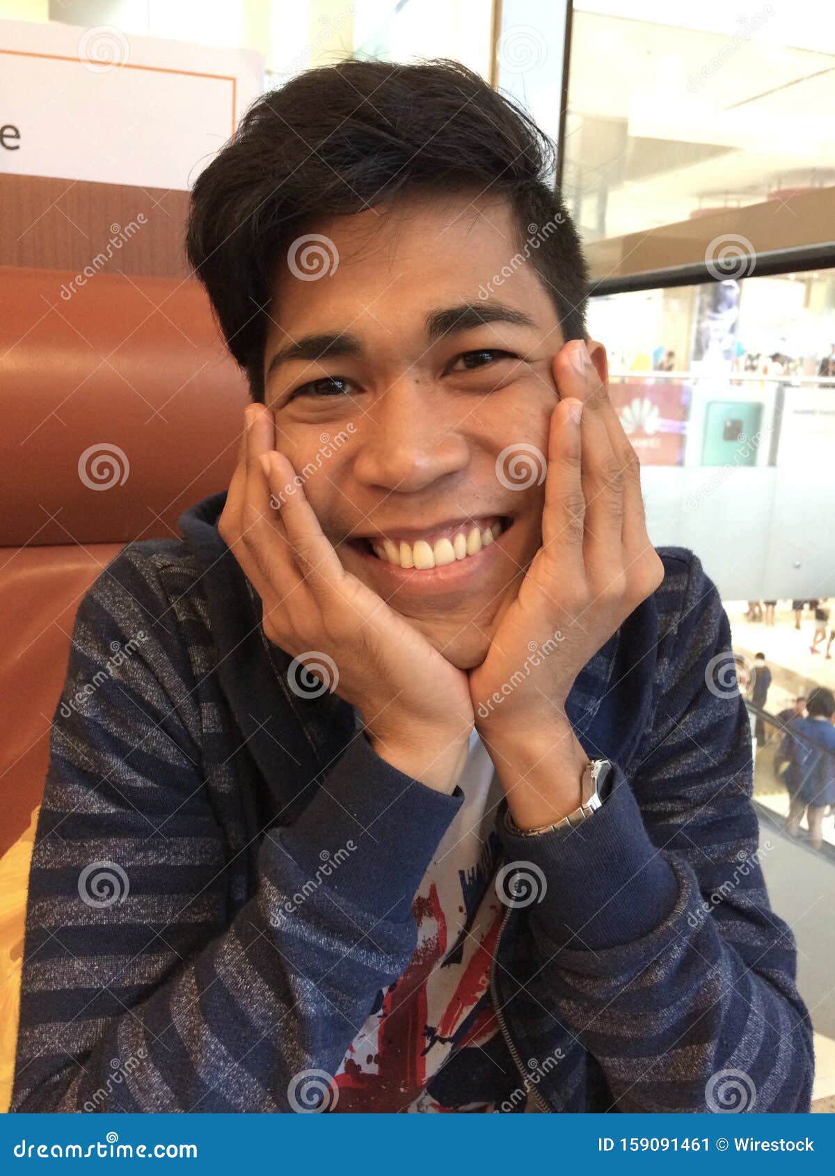Vertical Shot of a Happy Male Smiling and Acting Cute in Front of the ...