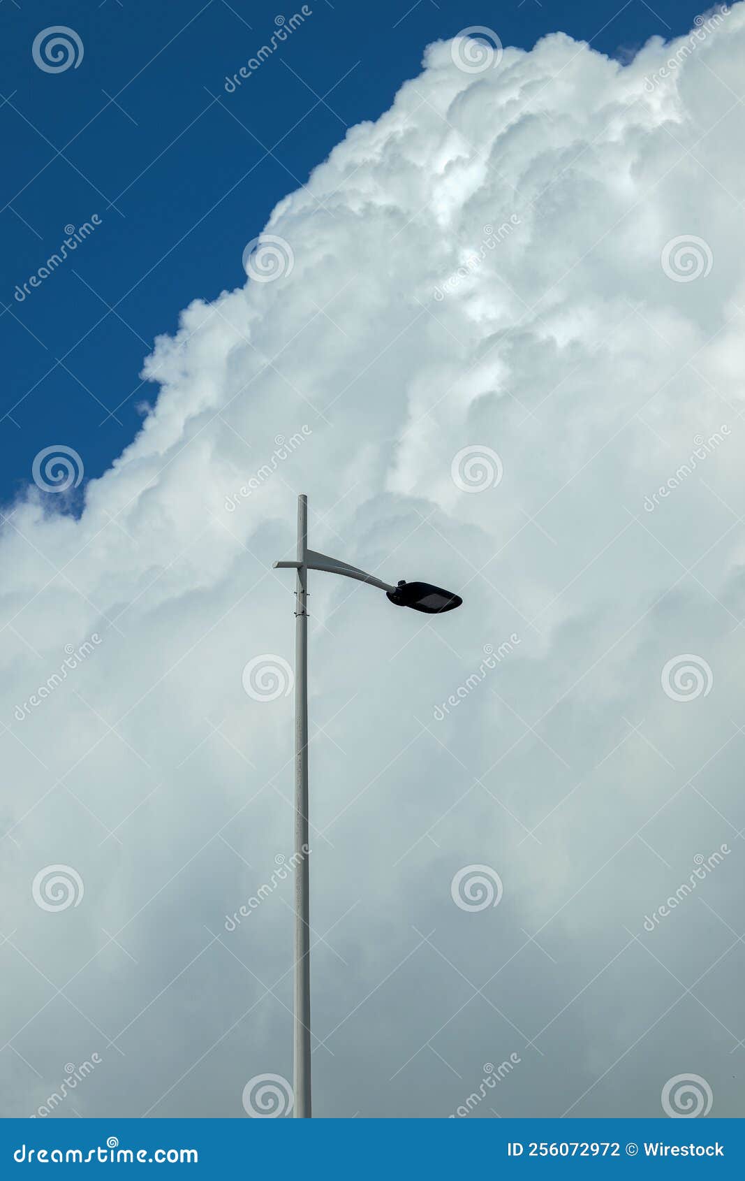 Vertical Shot of a Lamp Post with a Big White Cloud in the Background ...