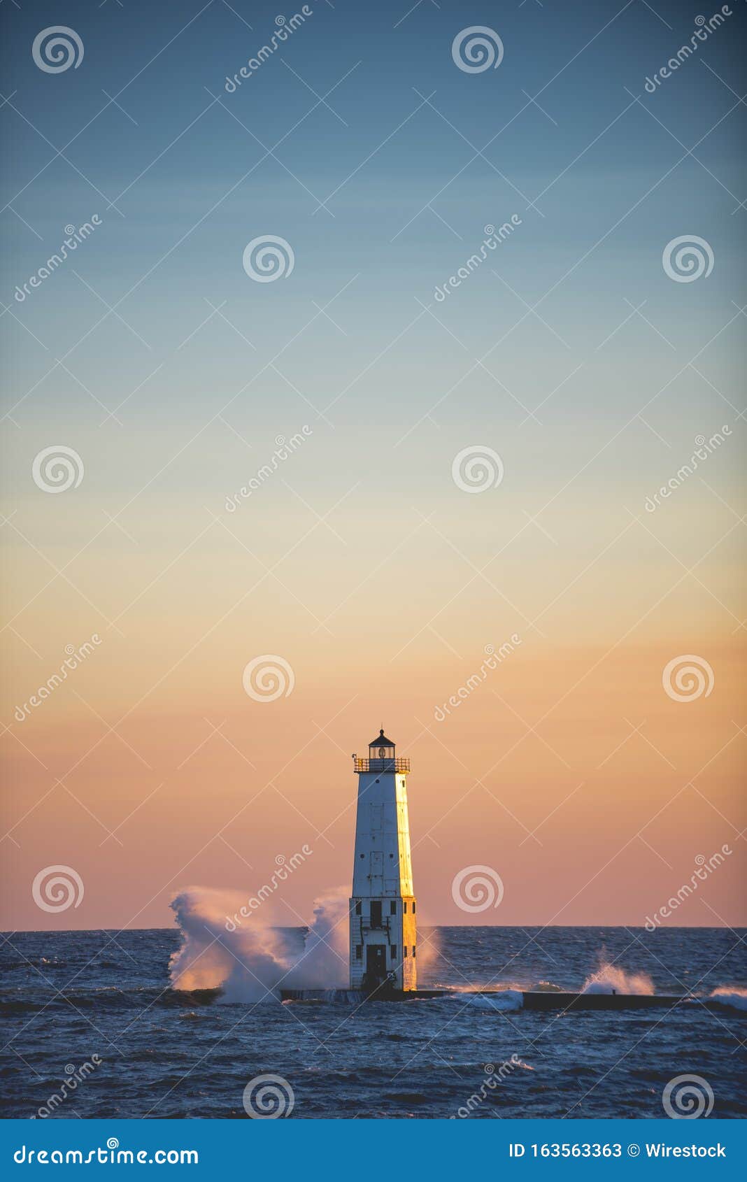 Vertical Shot of a Lighthouse in the Sea with the Waves Hitting the ...
