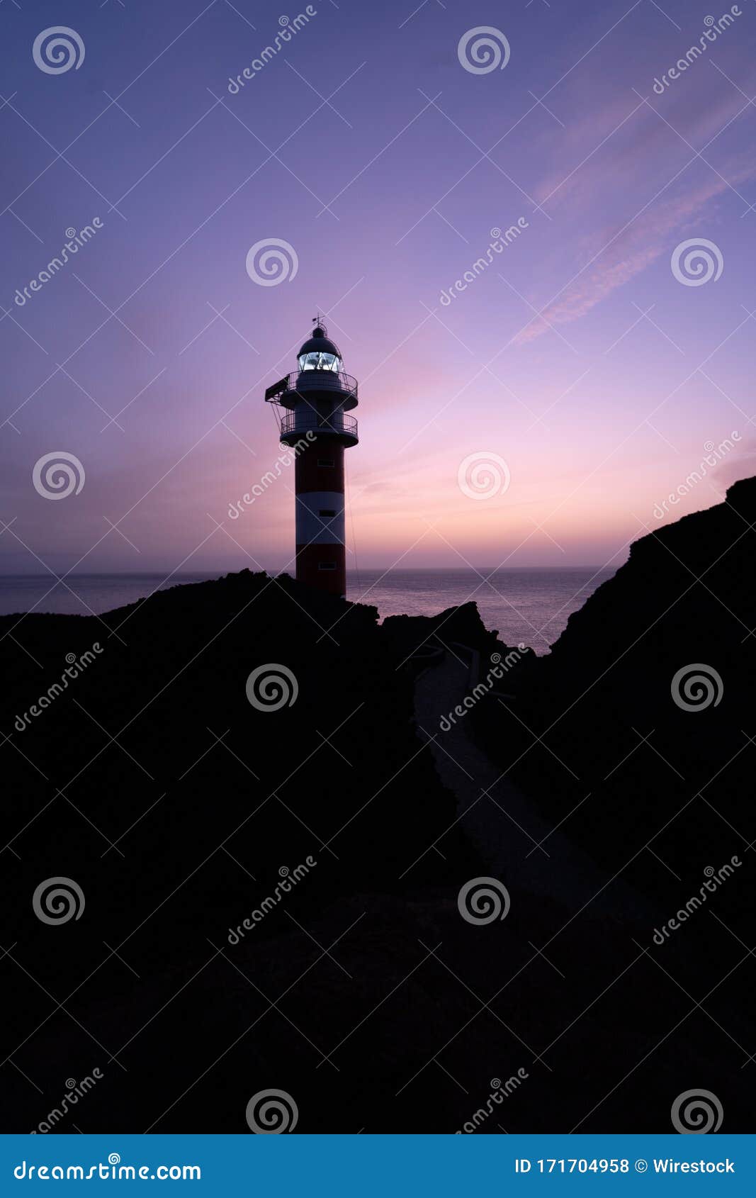 Vertical Shot of a Lighthouse on the Shore of the Sea with the Purple ...