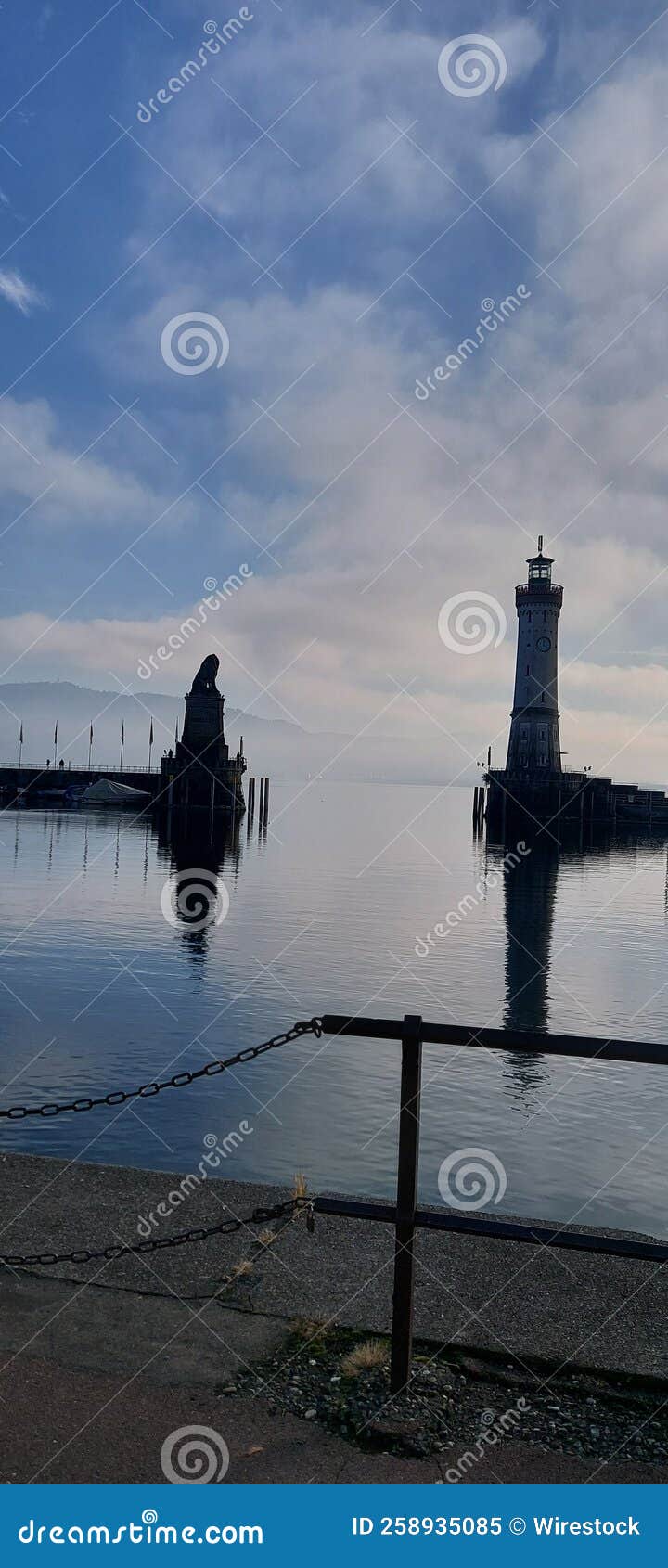 Vertical Shot of a Lighthouse in the Water with Visible Reflections on ...