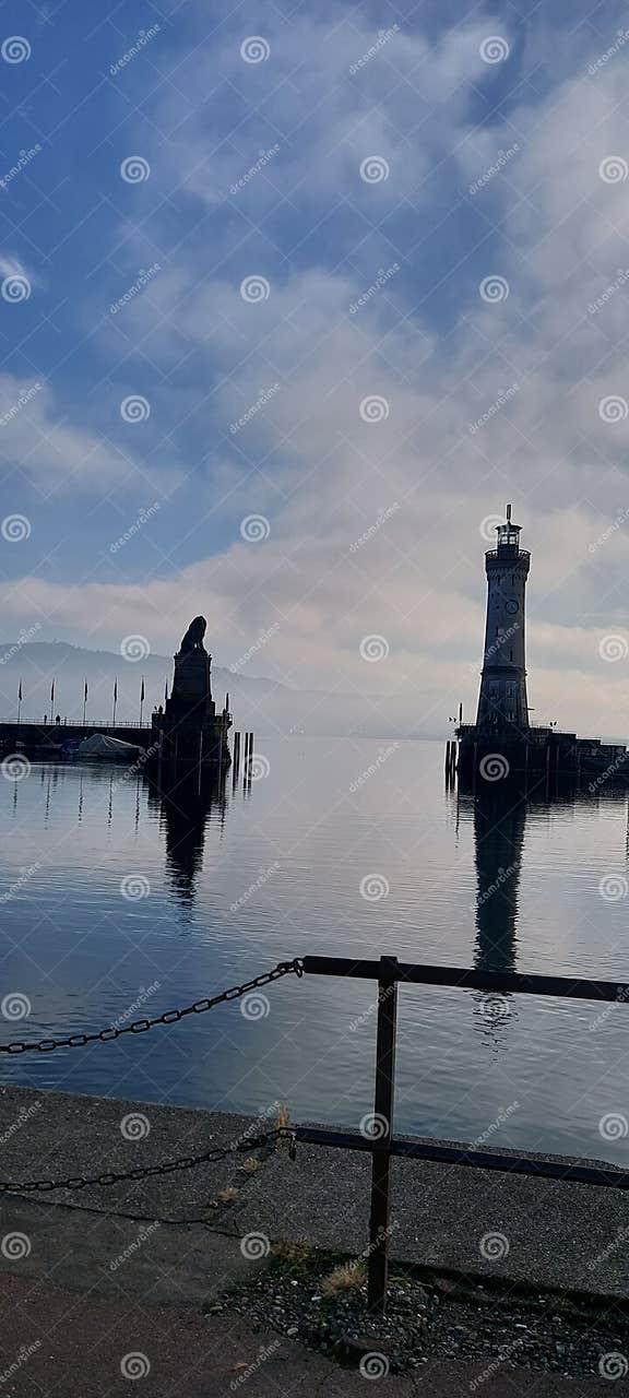 Vertical Shot of a Lighthouse in the Water with Visible Reflections on ...