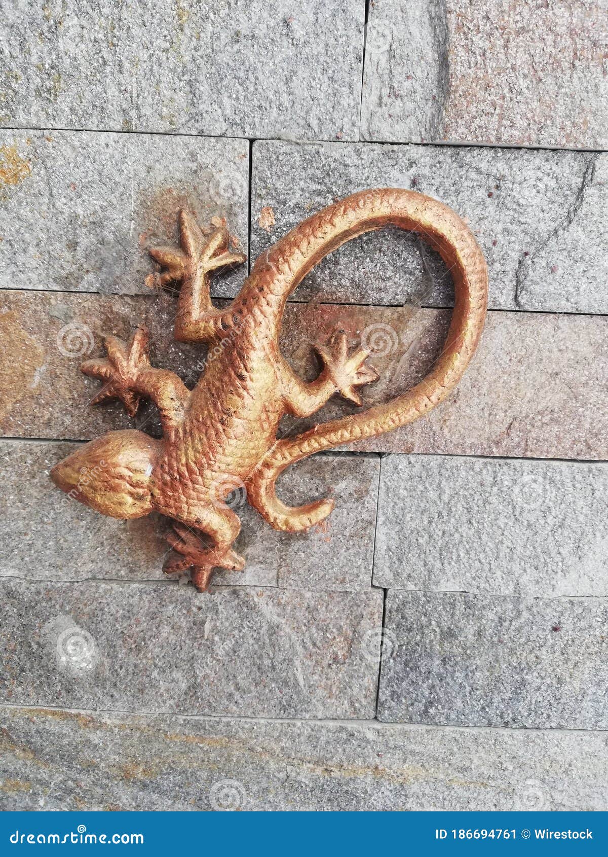 Vertical Shot of a Lizard Statue Painted Copper Color on a Stone ...