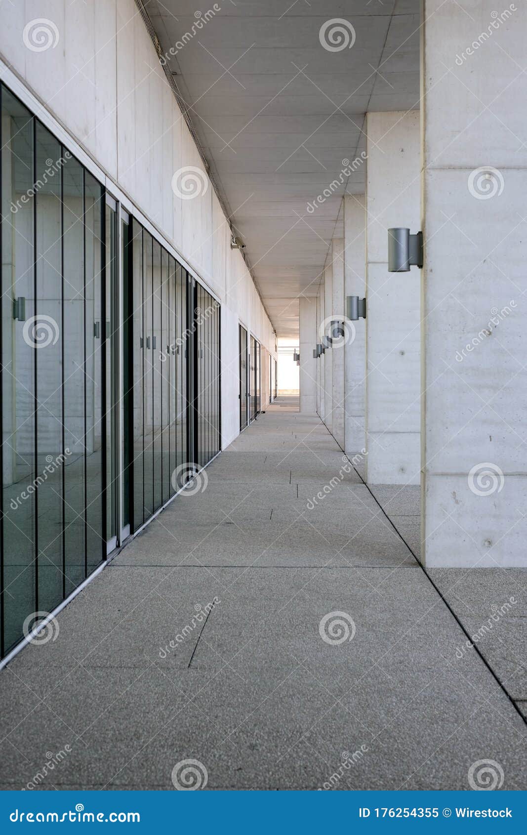 Vertical Shot of a Long Outdoor Corridor of a White Stone Building ...