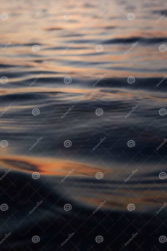 Vertical Shot of the Mild Waves of the Lake with the Sunset Light ...