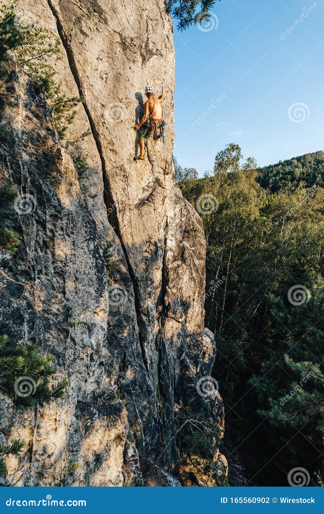 Vertical Shot of a Mountain Climber Climbing the Rocks Using His ...