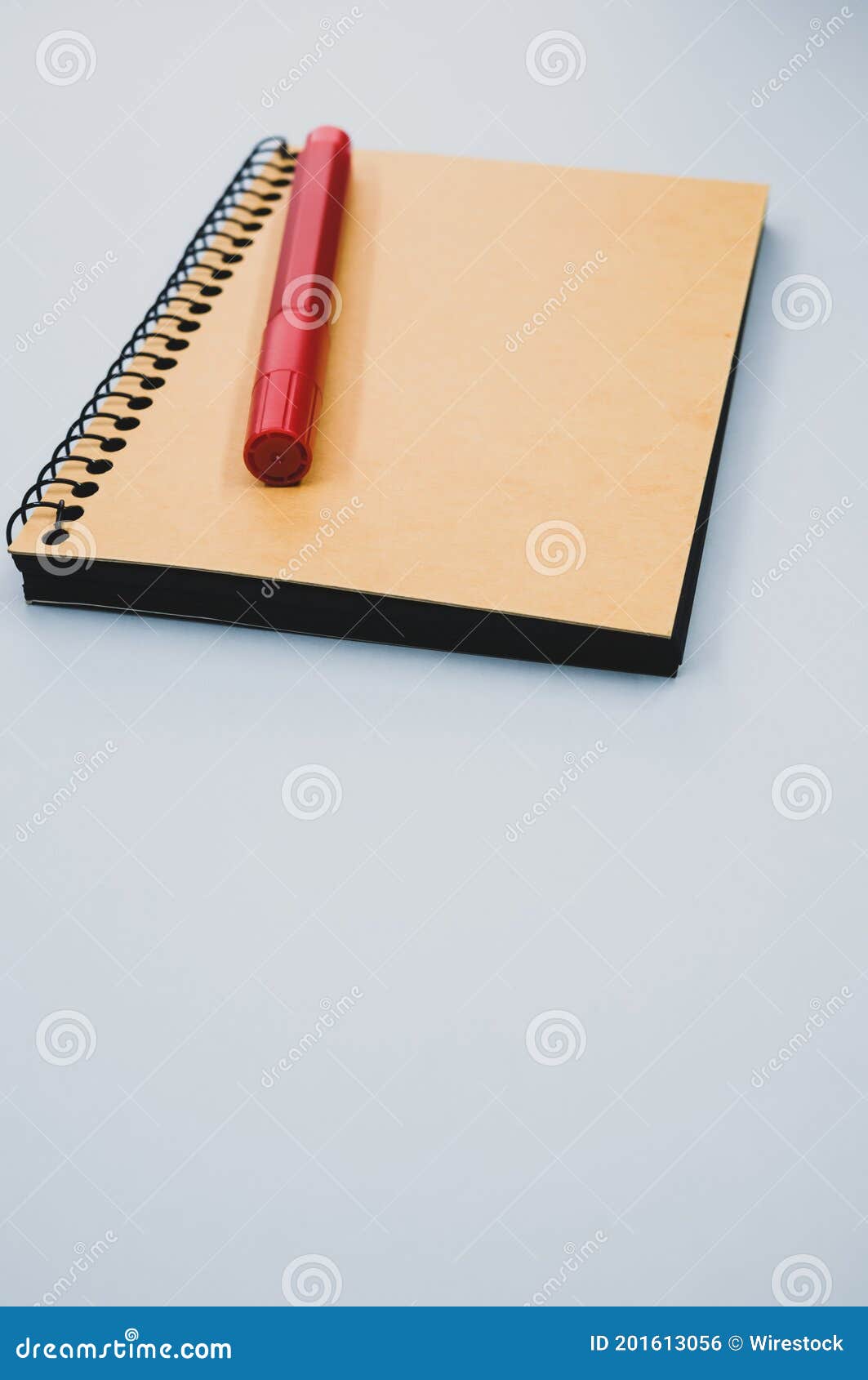 Vertical Shot of a Notebook and a Marker on a Blue Surface Stock Photo ...