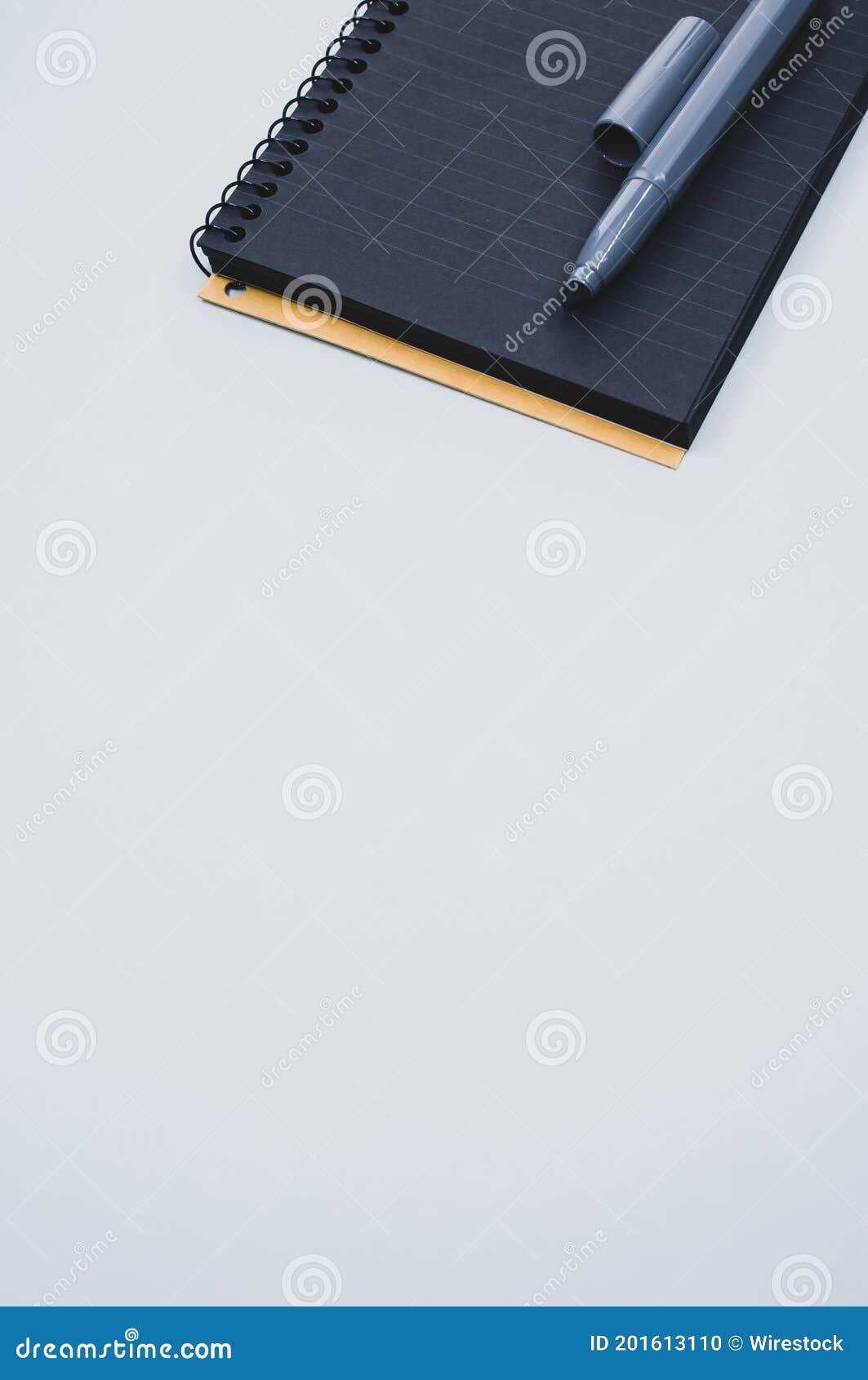 Vertical Shot of a Notebook and a Marker on a Blue Surface Stock Photo ...