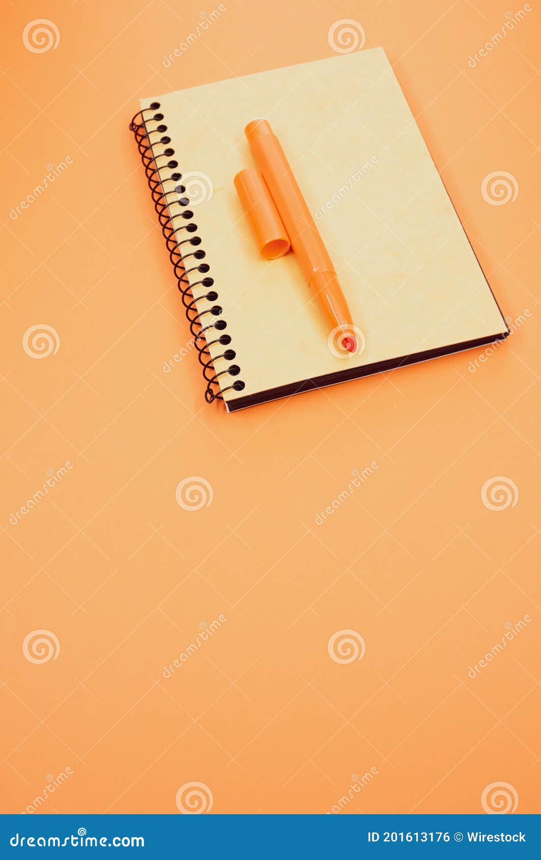 Vertical Shot of a Notebook and an Orange Marker on an Orange Surface ...