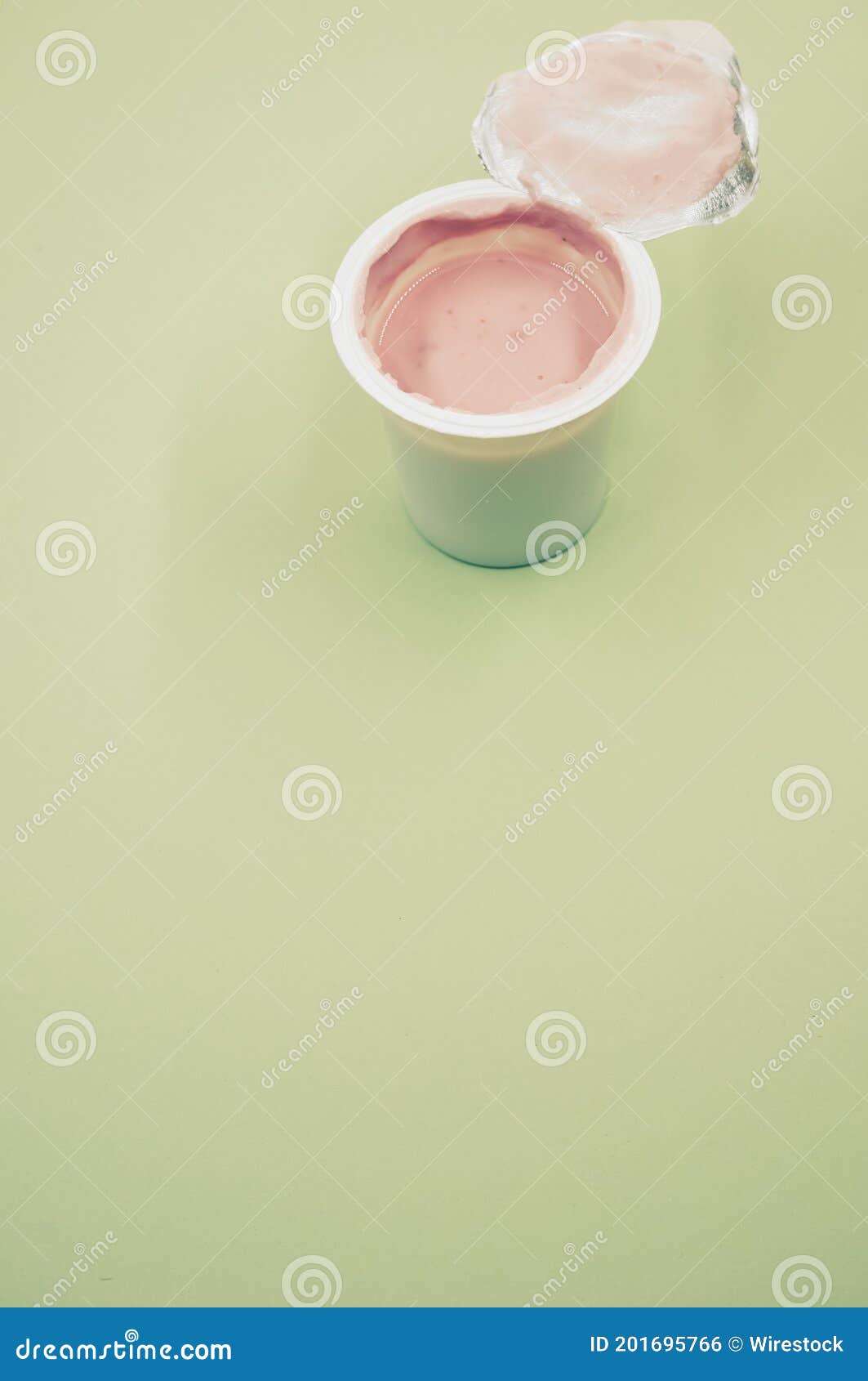Vertical Shot of an Opened Plastic Container of Fruit Yogurt on a Green ...
