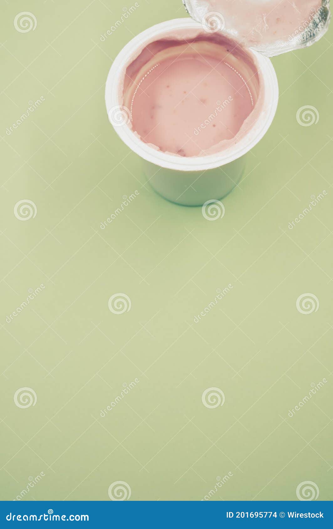 Vertical Shot of an Opened Plastic Container of Fruit Yogurt on a Green ...
