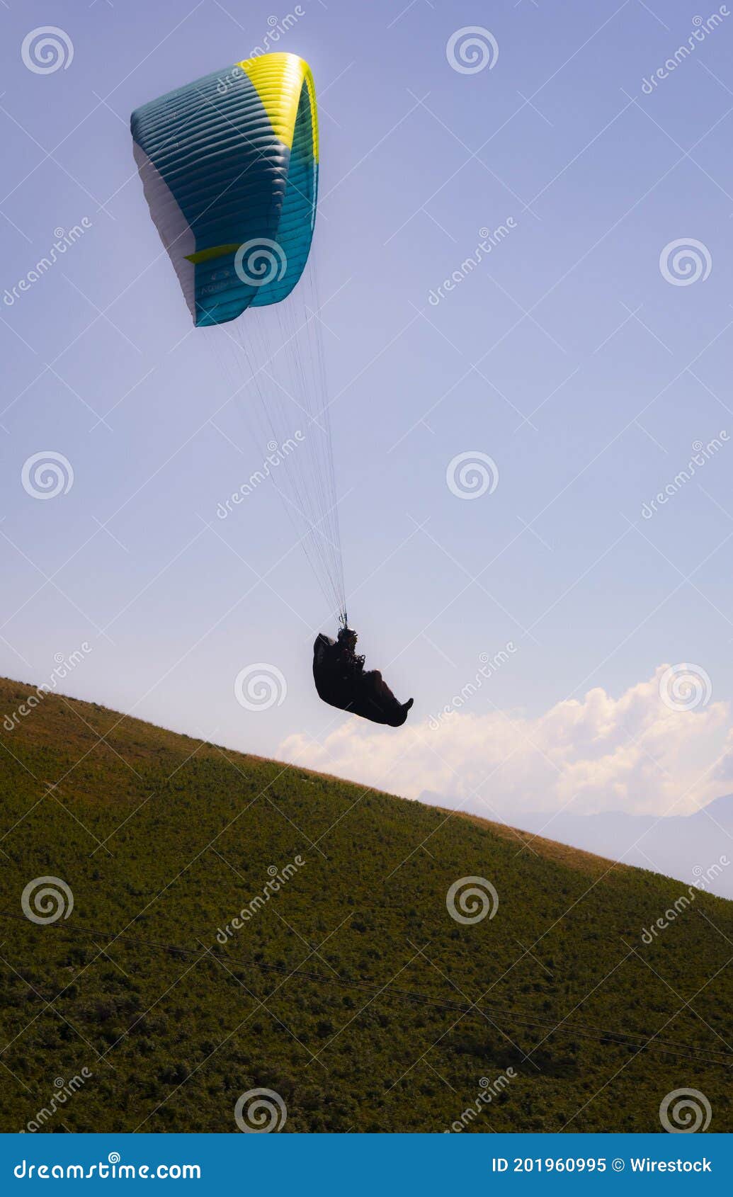 Vertical Shot of a Parasailer Landing on a Hill Stock Image - Image of ...