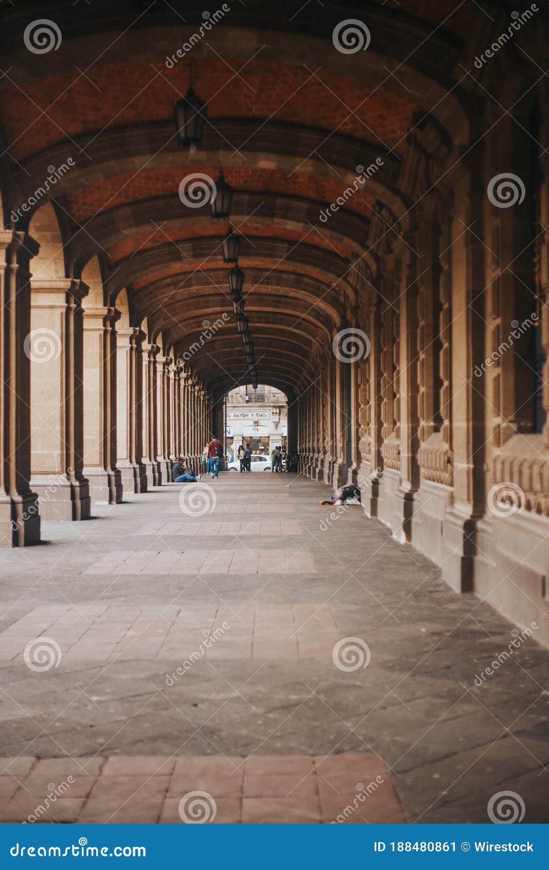 Vertical Shot of People in an Arc Hall in the City with Lights on the ...