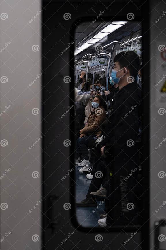Vertical Shot Of People Wearing Face Masks On A Crowded Public Subway