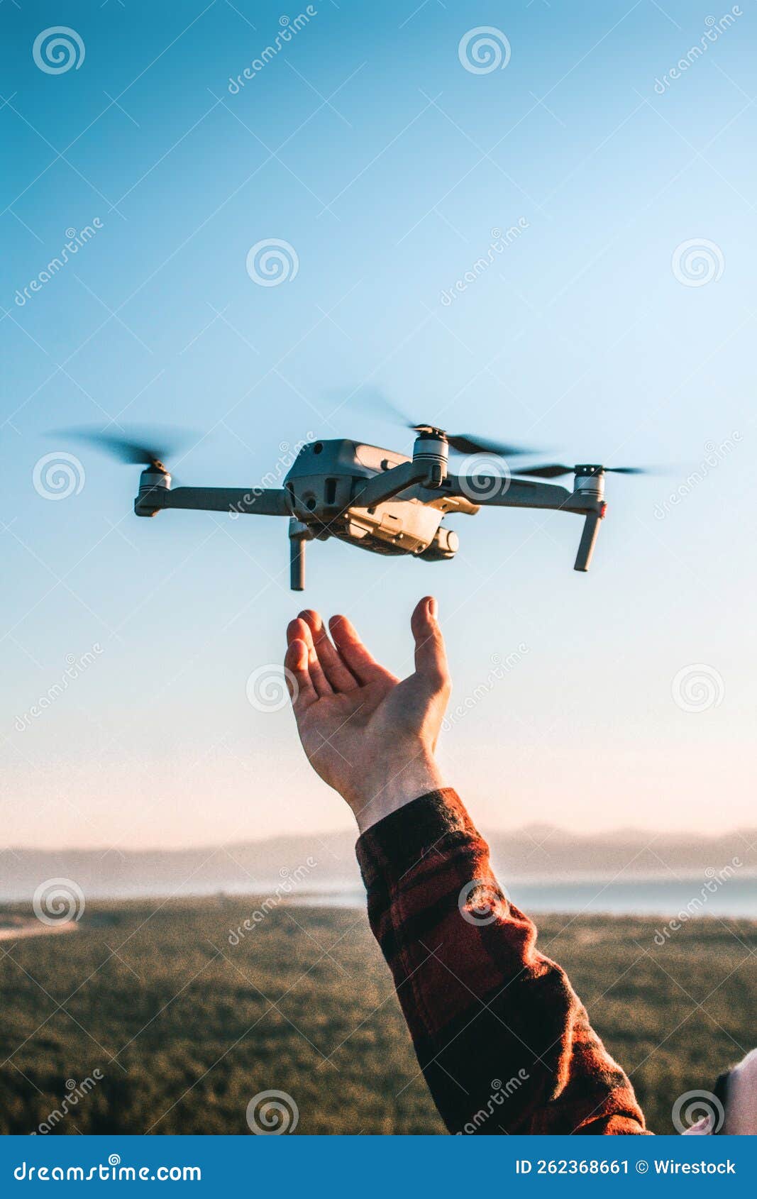Vertical Shot of a Person Launching a Modern Drone in a Field Under the ...